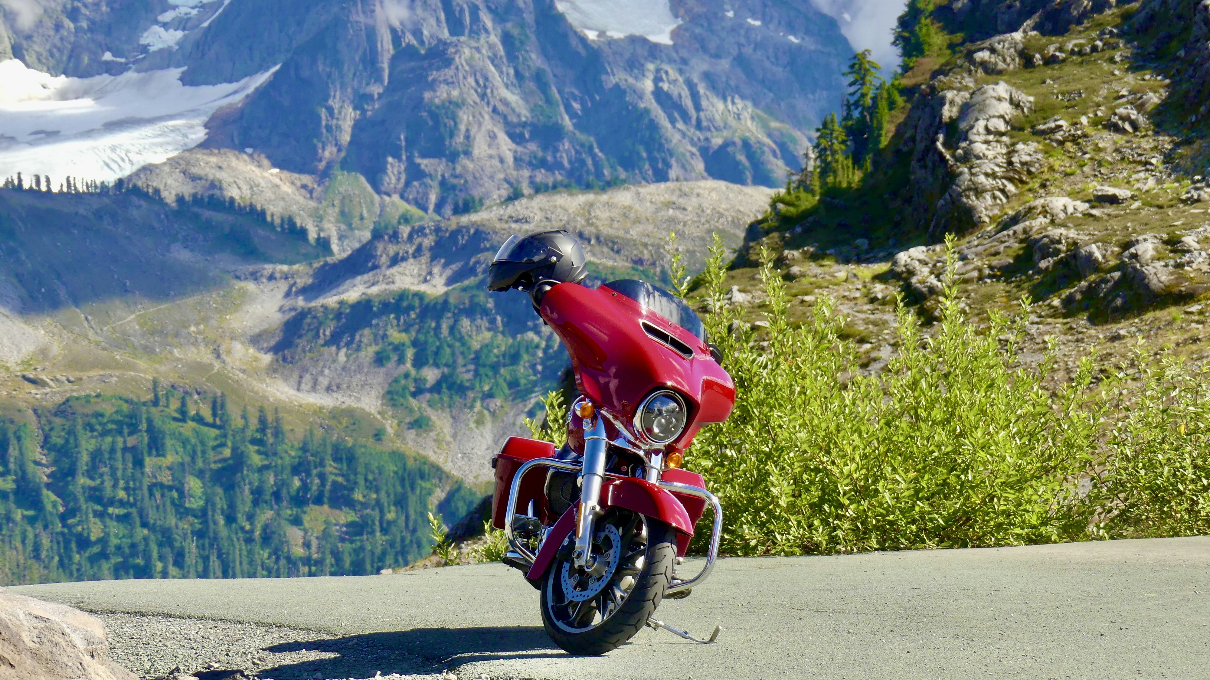 A red motorcycle parked on the side of a mountain