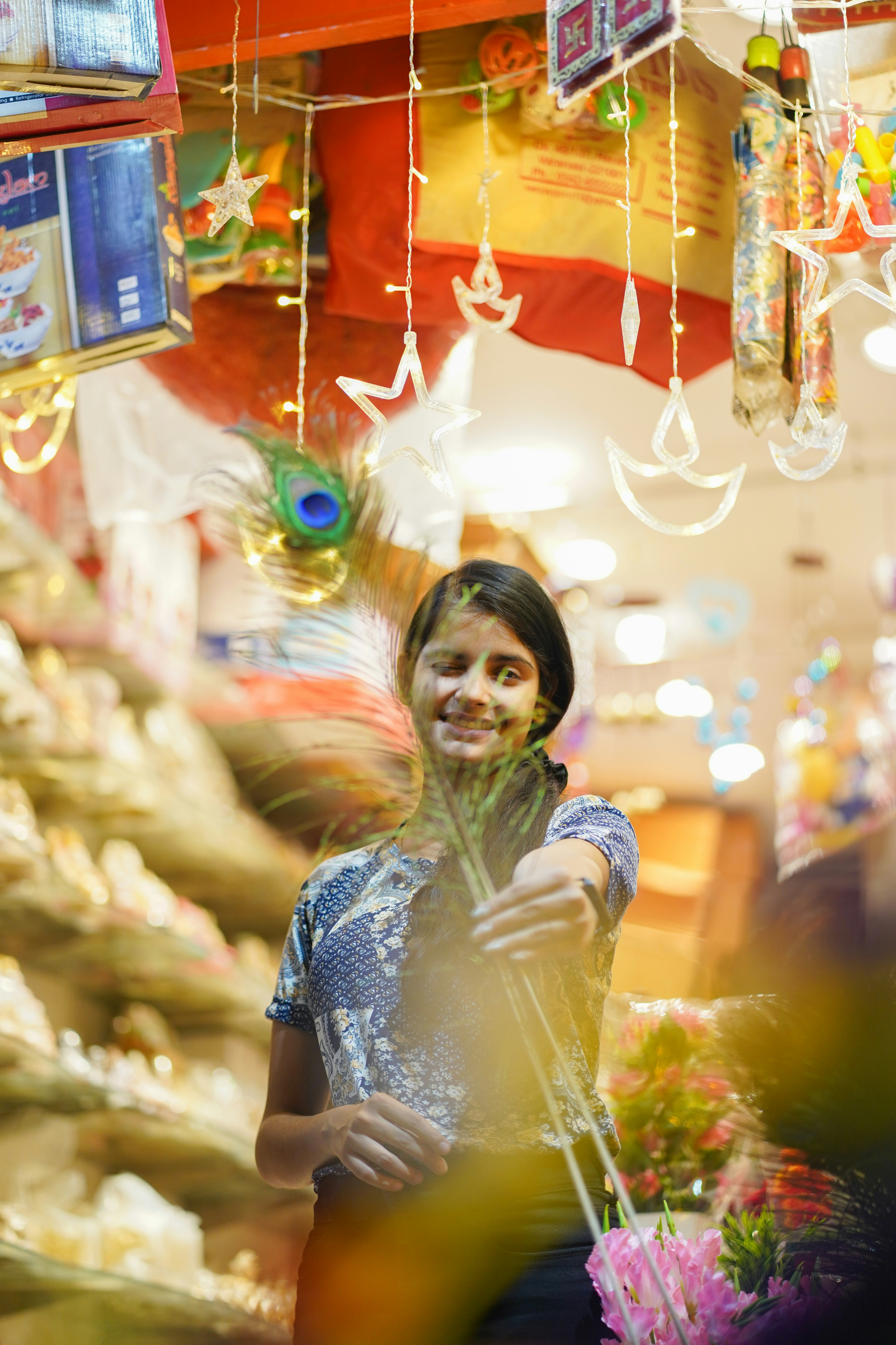Smiling Shopkeeper Reaching Through a Festive Display