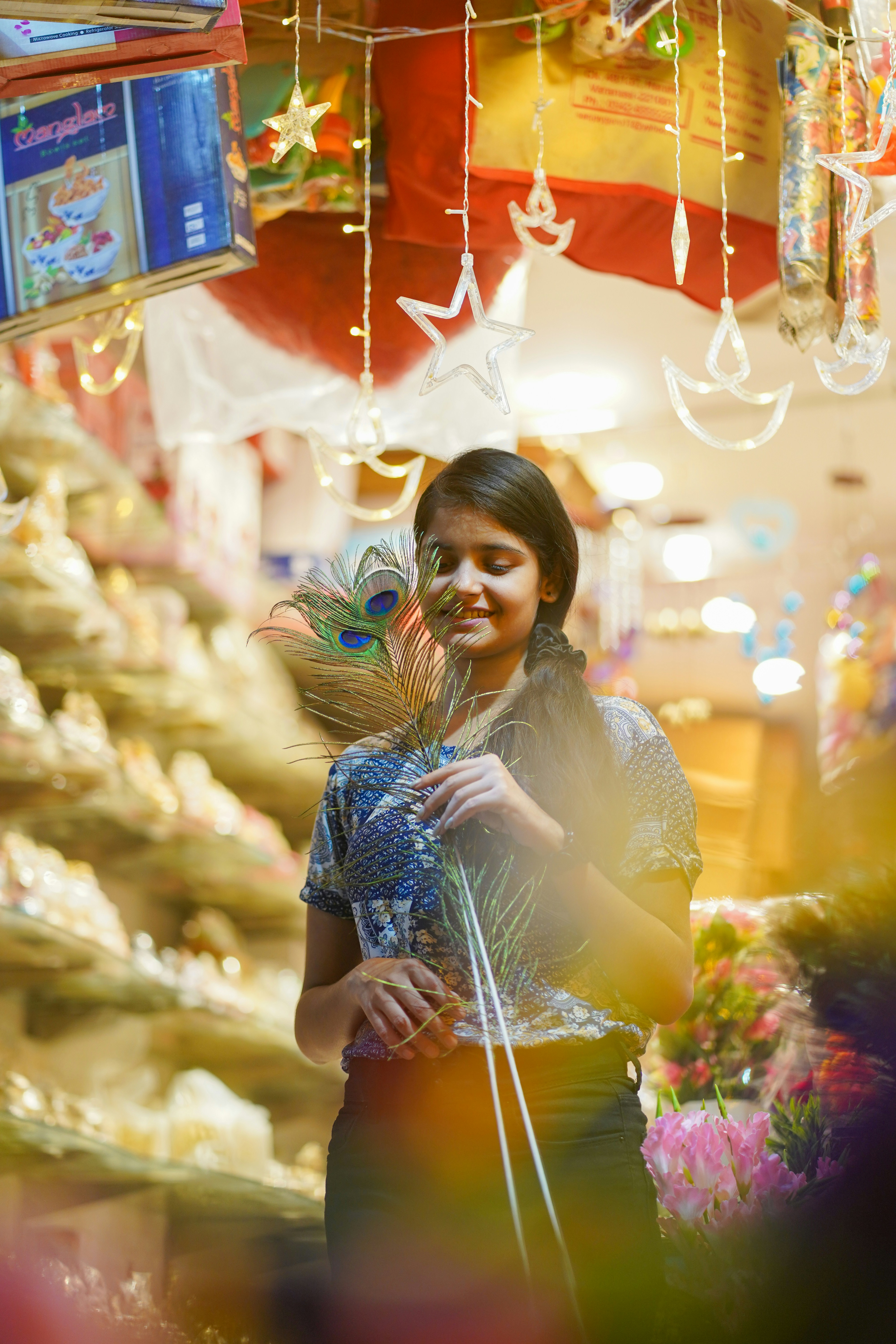 Peacock Glow: A Girl with Feathers Under Festive Lights