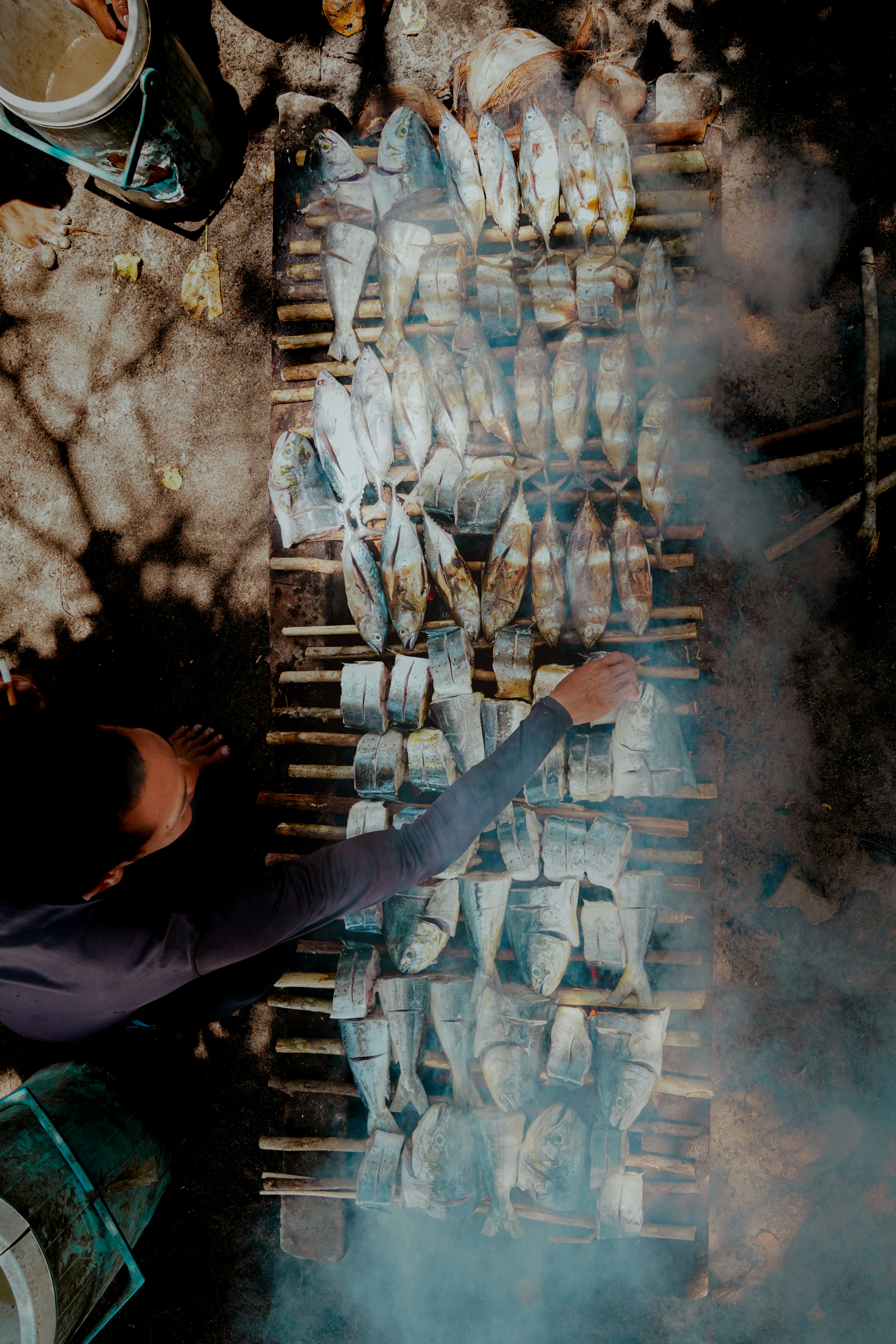 Aerial Grilling: Fish on Bamboo Racks Smoldering Under Smoke