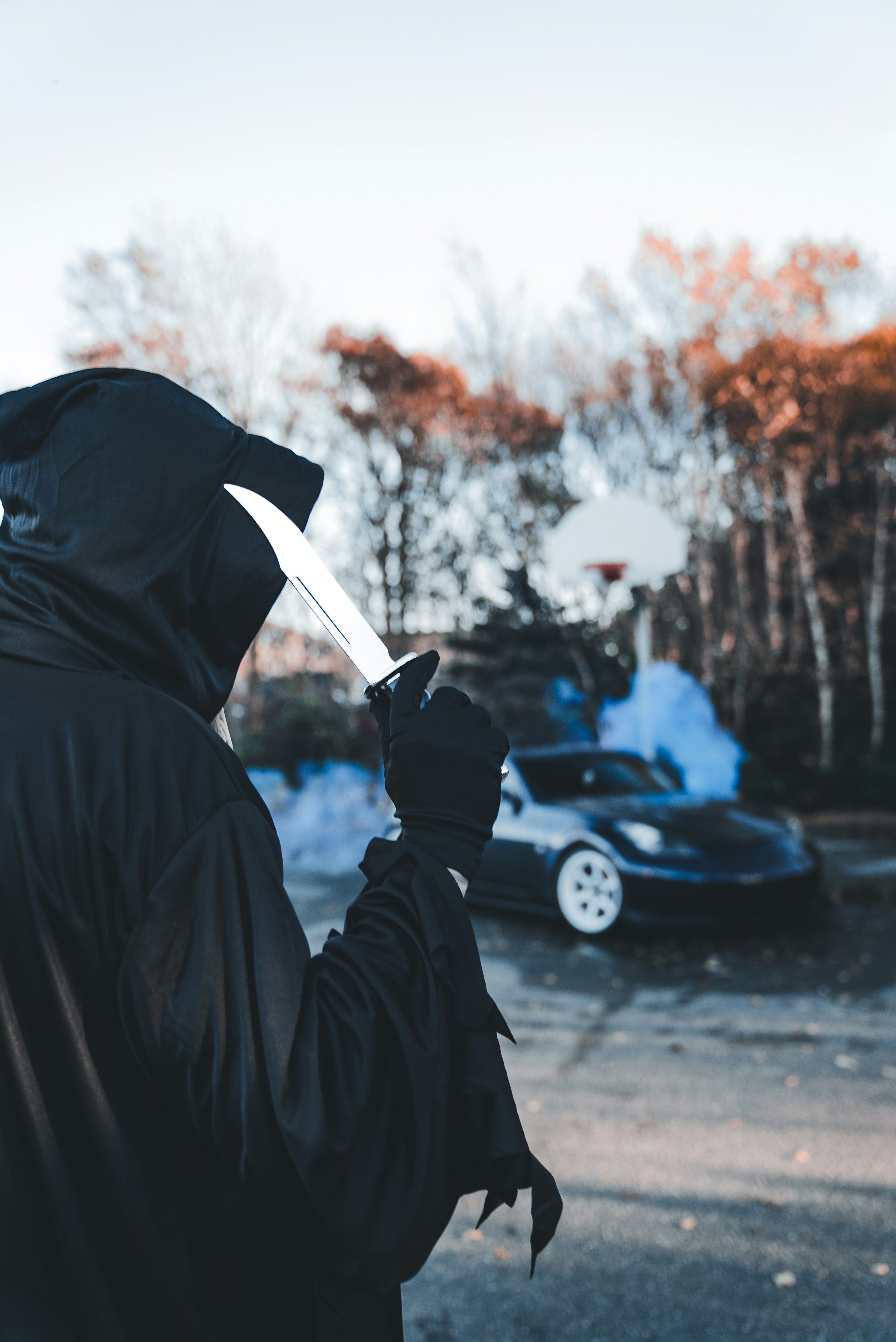 A person in a hooded jacket holding a knife photo – Free Knife Image on ...