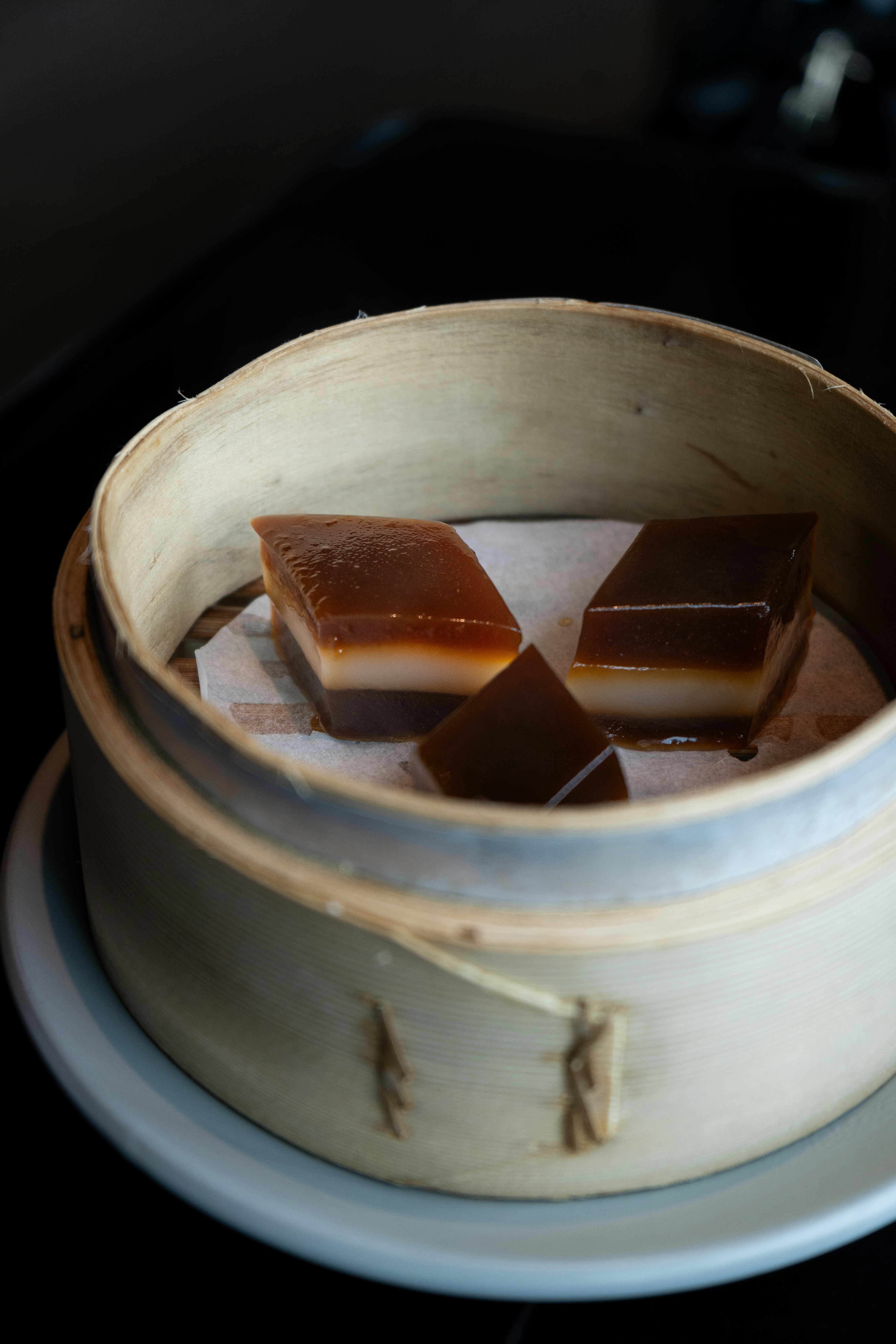 Steam-Softened Delicacy: Caramel Gel Squares Nestled in a Bamboo Steamer