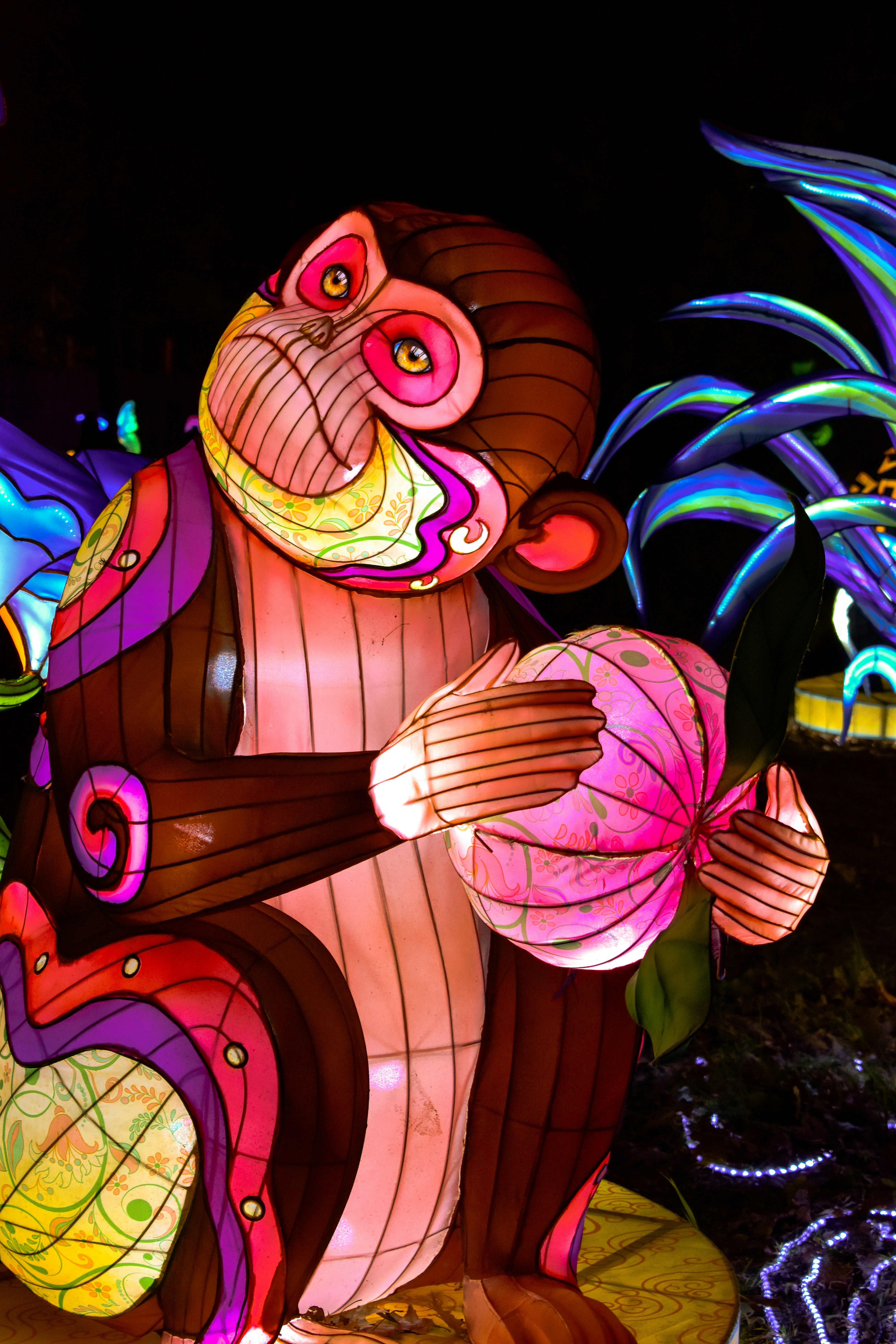 Neon-Glow Monkey Lantern Cradles a Pink Orb in a Night Parade