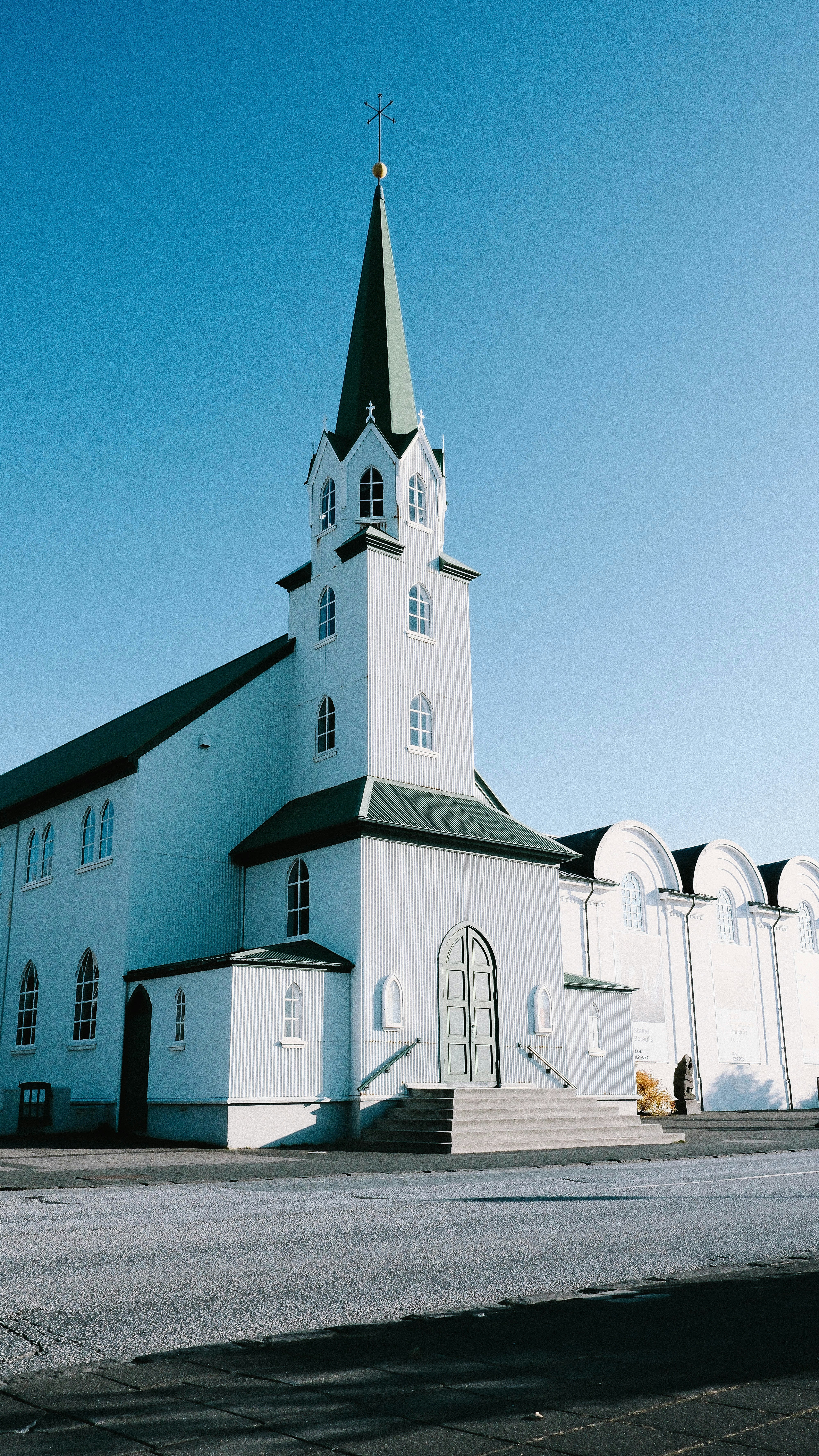 A large white church with a steeple on a clear day photo – Free ...