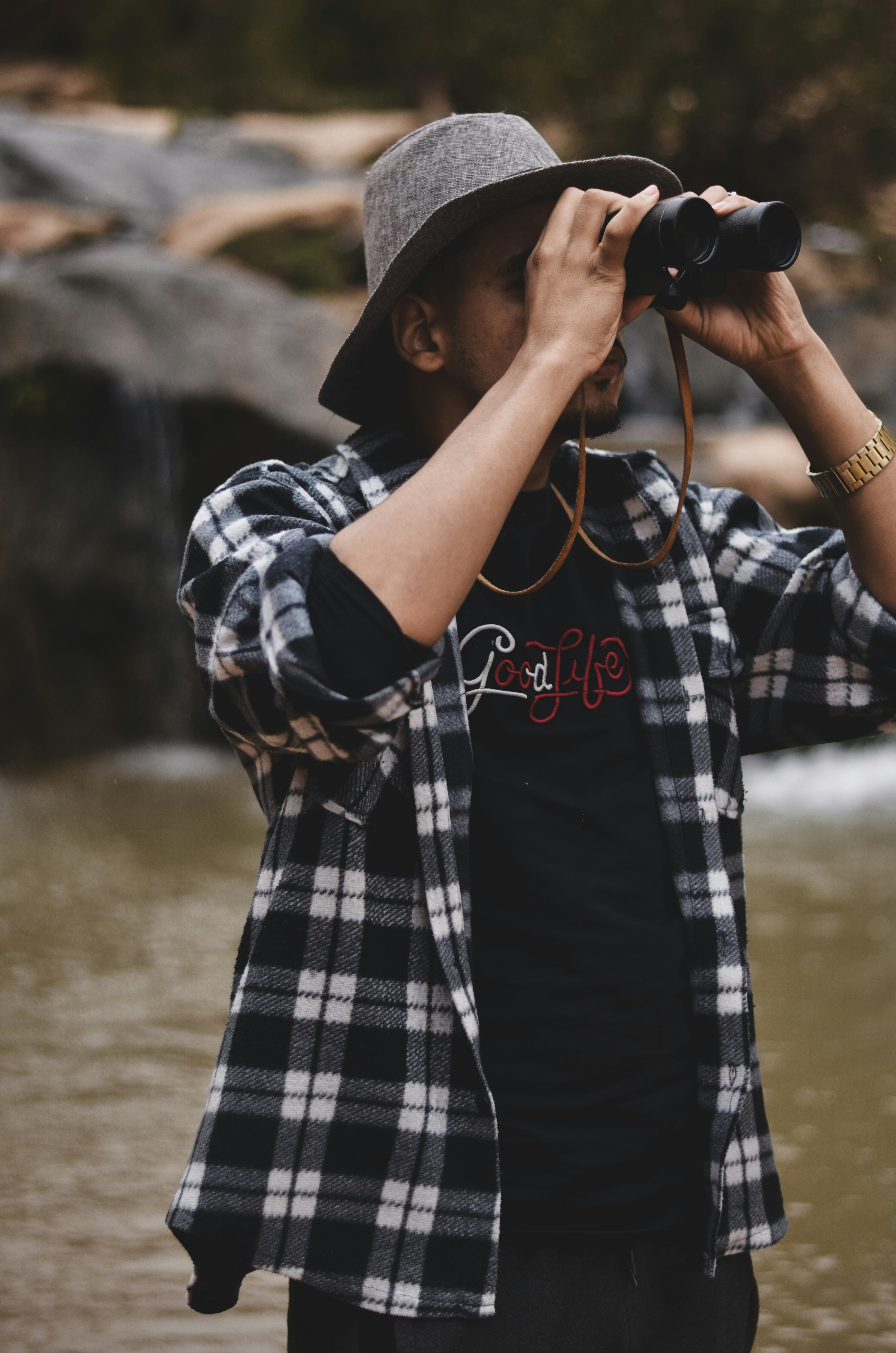Binocular gaze: a traveler scans the world with a vintage fedora