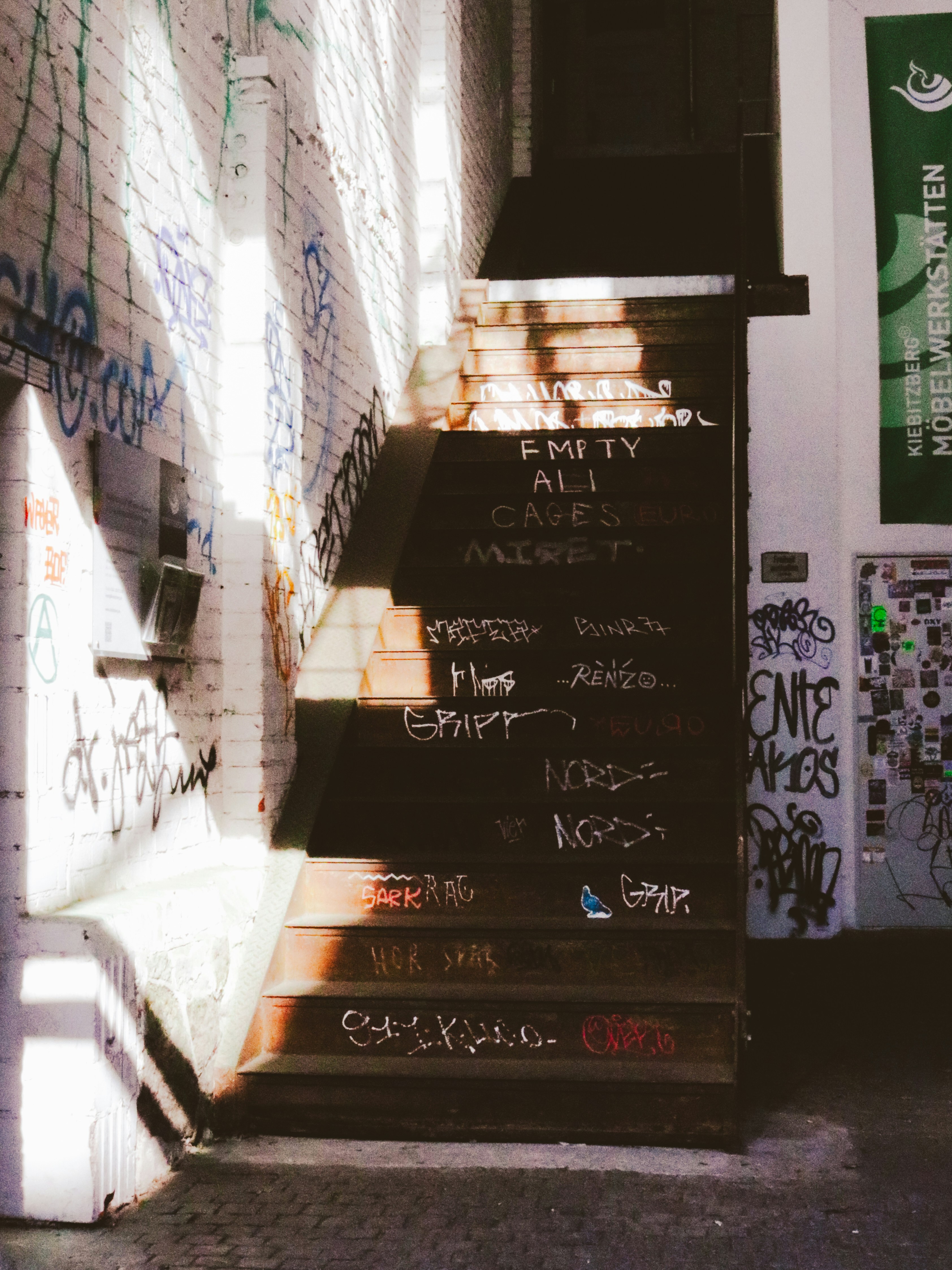 Sunlit Graffiti Staircase: A Narrow Alley's Painted Descent