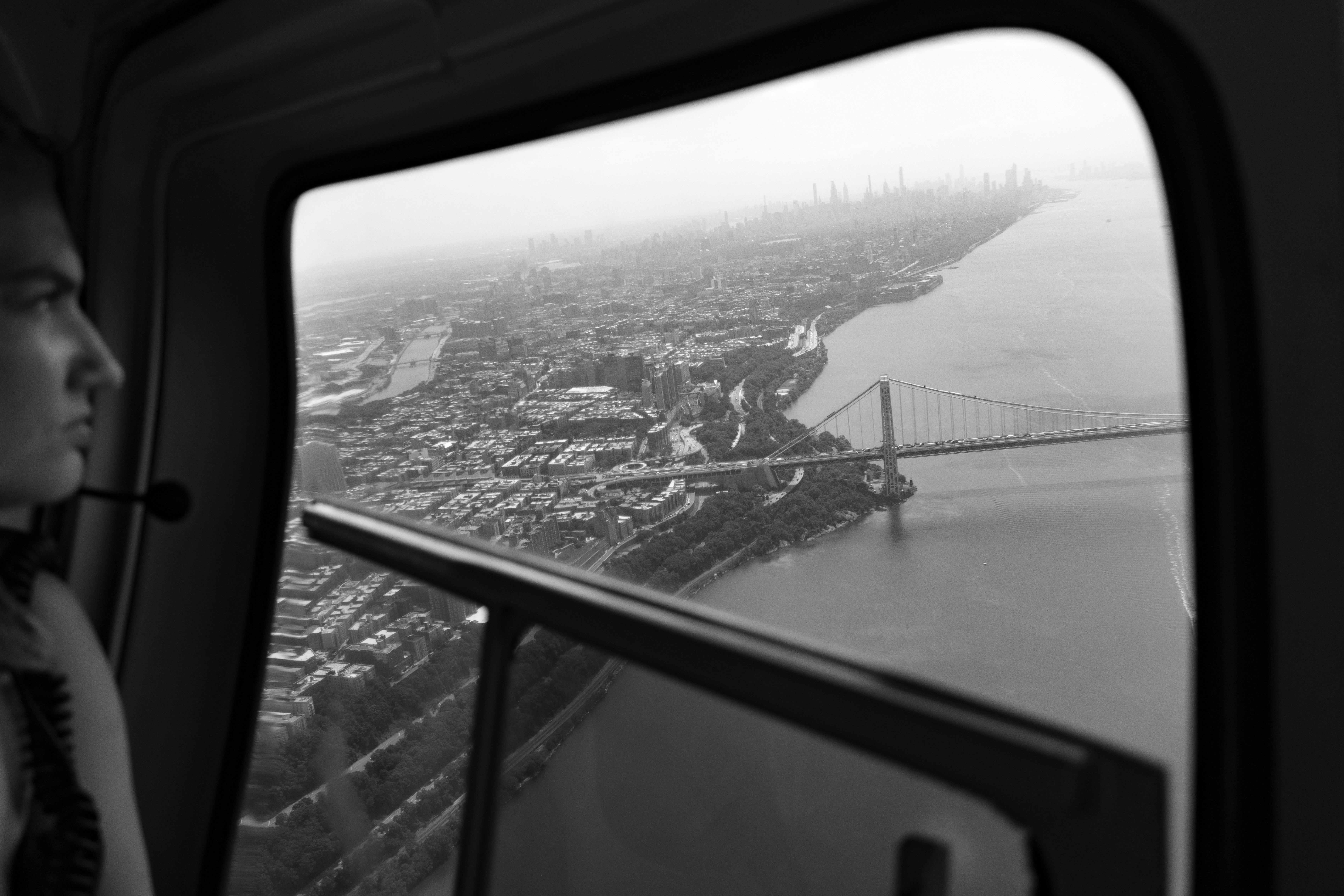 Aviator’s View: City Ribbon and River Bridge Framed by Cabin Window