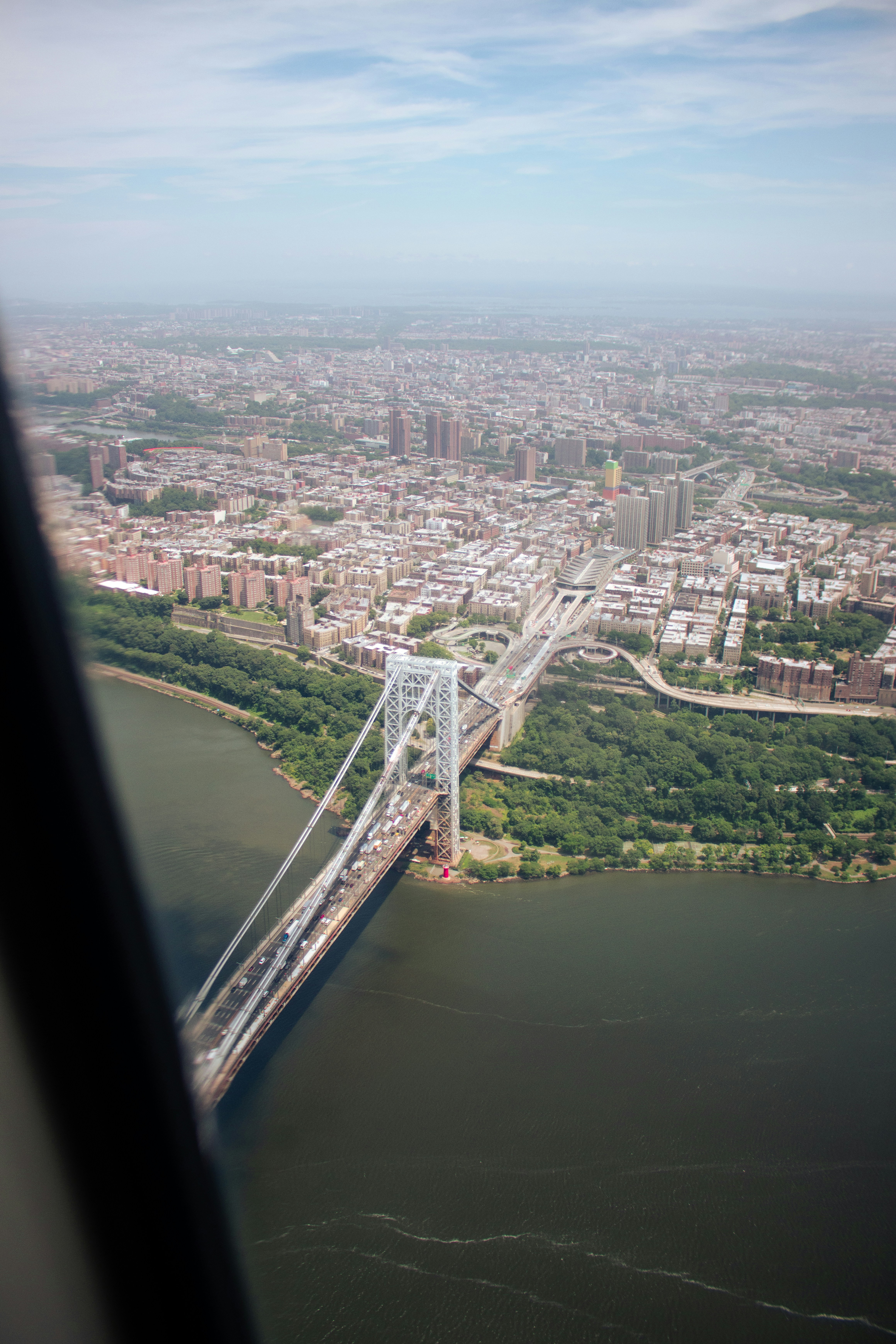 Riverside Cityscape: Aerial View of a Suspension Bridge Framing Urban Sprawl