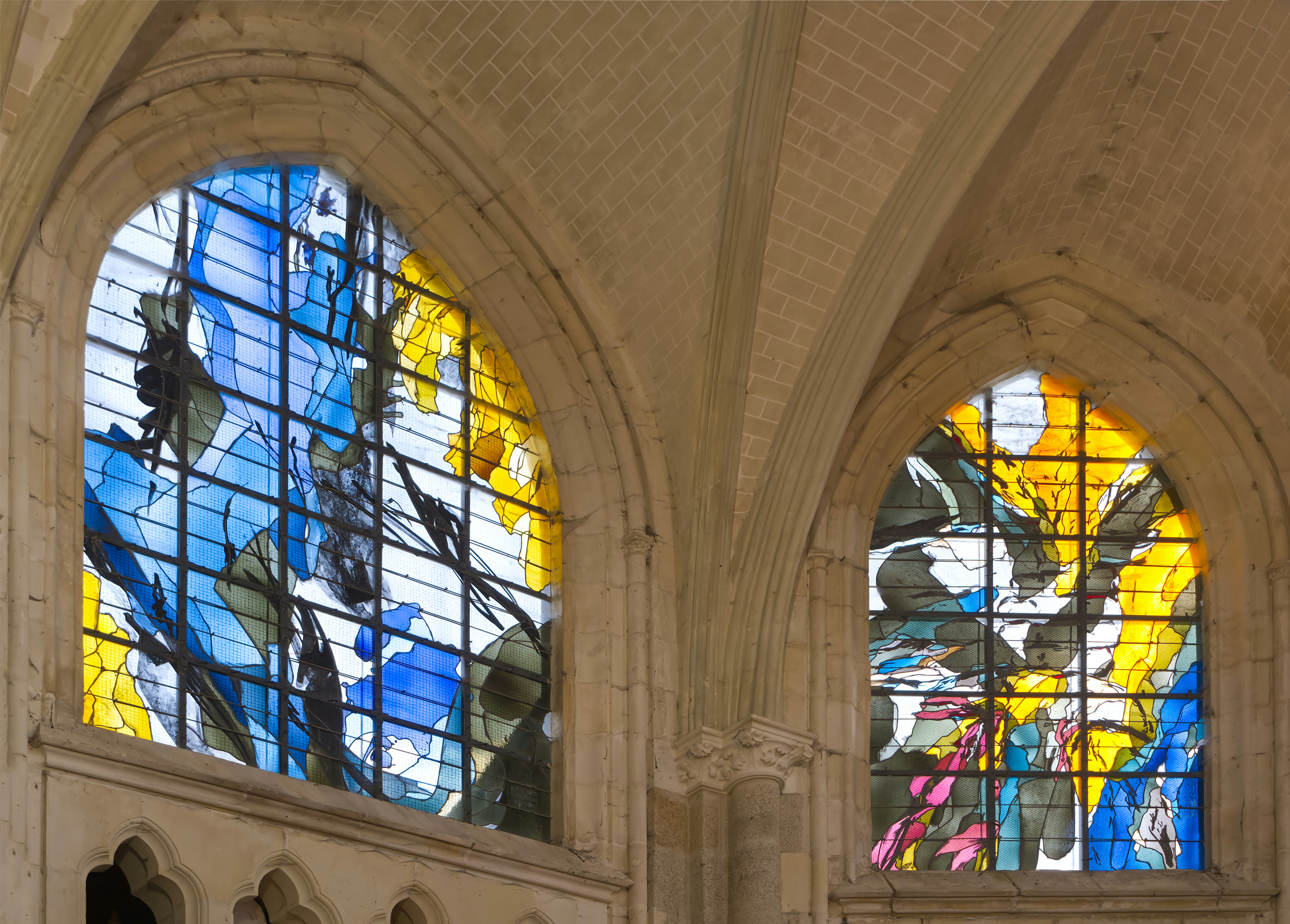 Colorful stained glass windows with abstract flame patterns in a neo-gothic church.