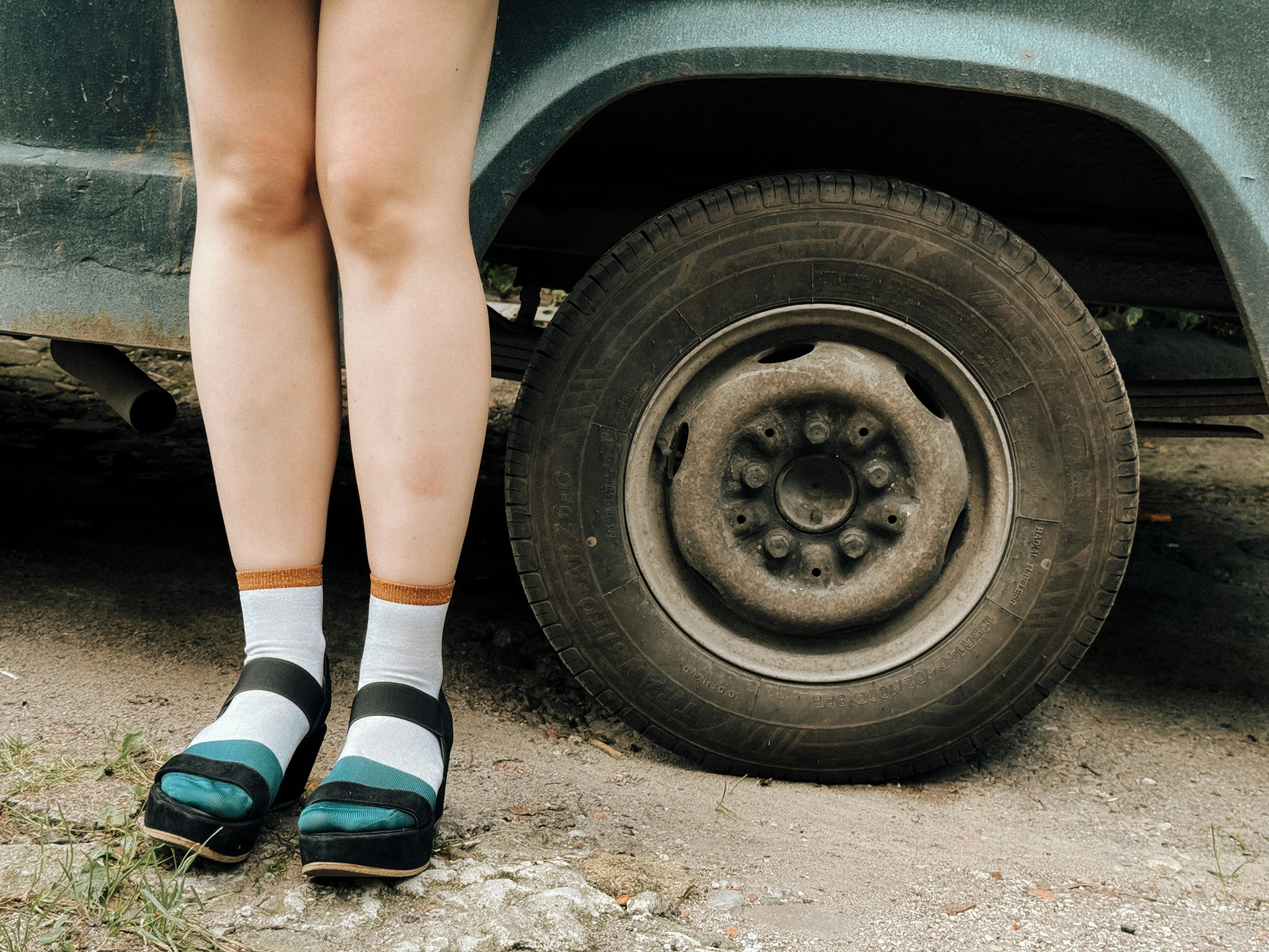 Grounded in Contrast: Colorful Socks by a Weathered Wheel