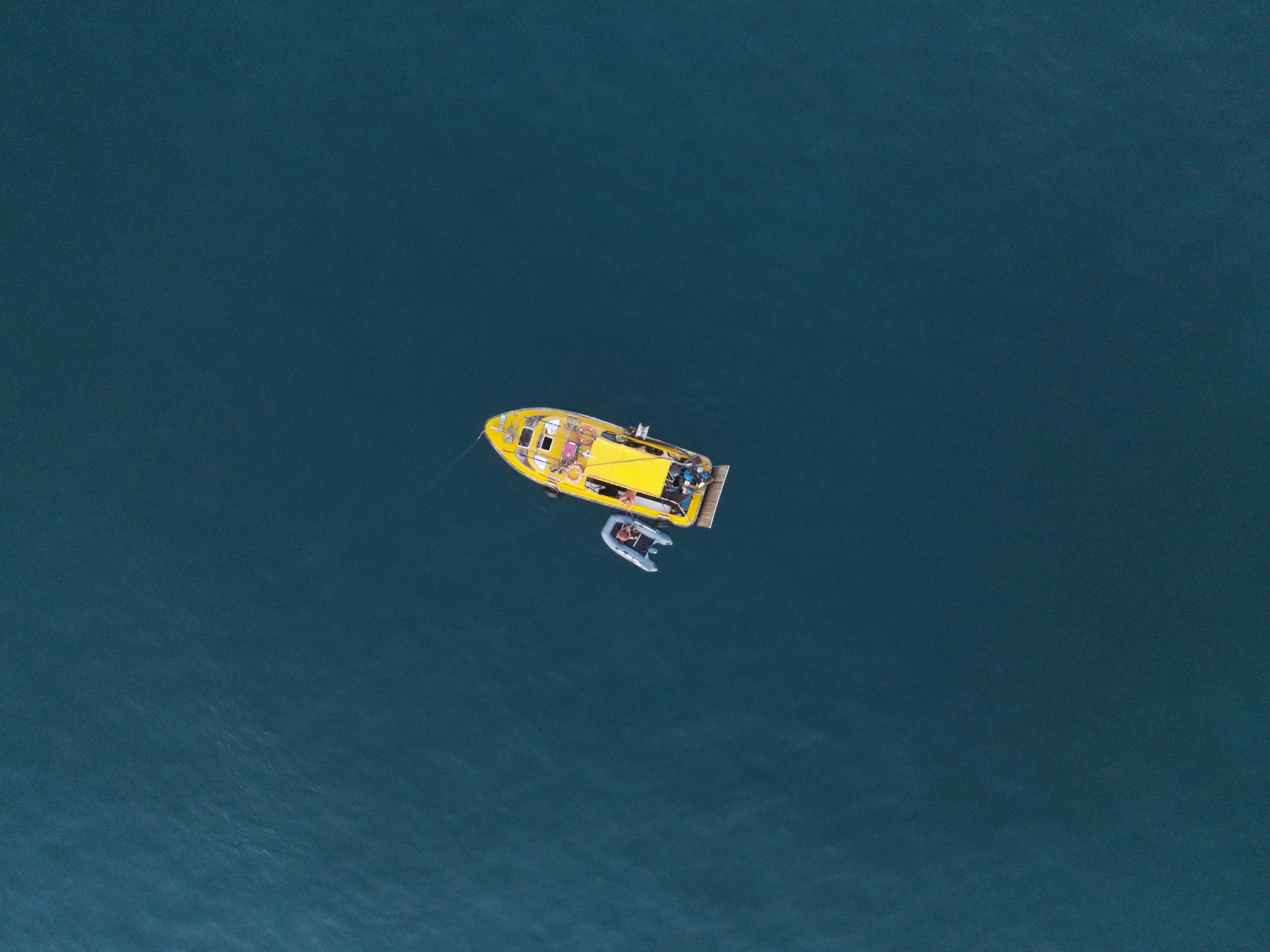 A yellow boat floating in the middle of the ocean photo – Free Land ...