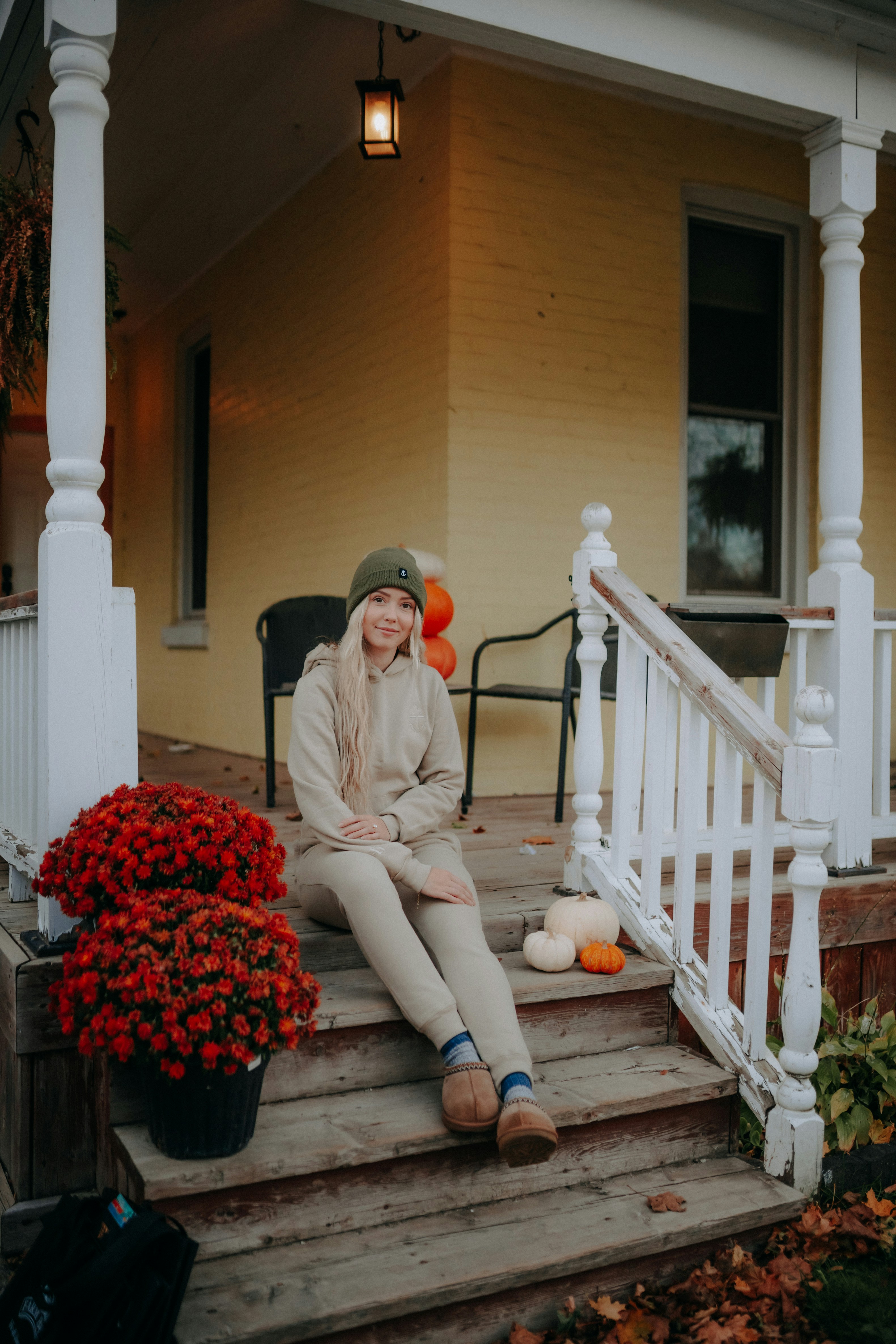 Cozy Veranda Portrait: Beige Knit, Lantern Light, and Autumn Pumpkins