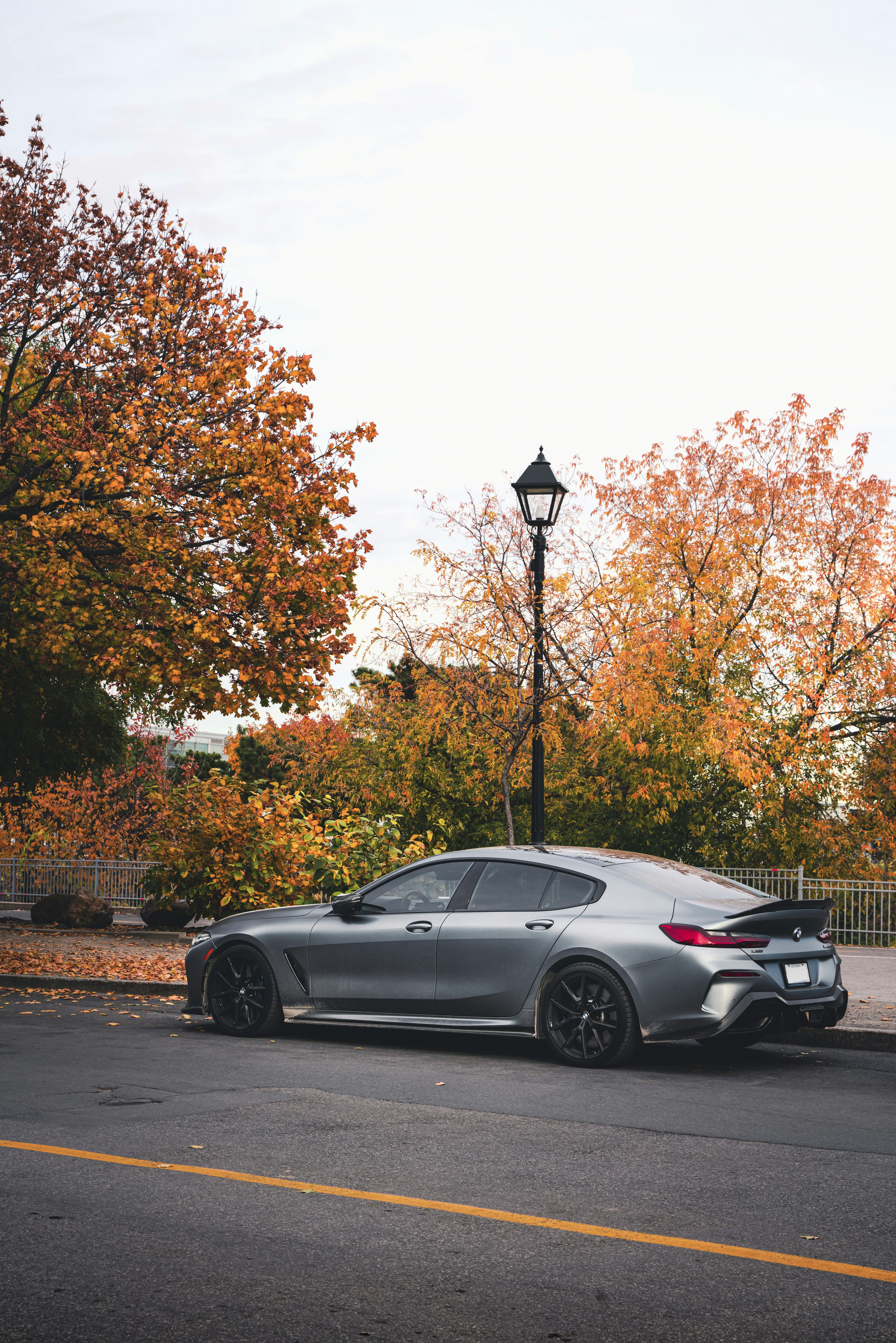 Autumn Street Stillness: A Silver Sports Sedan Beneath a Lantern