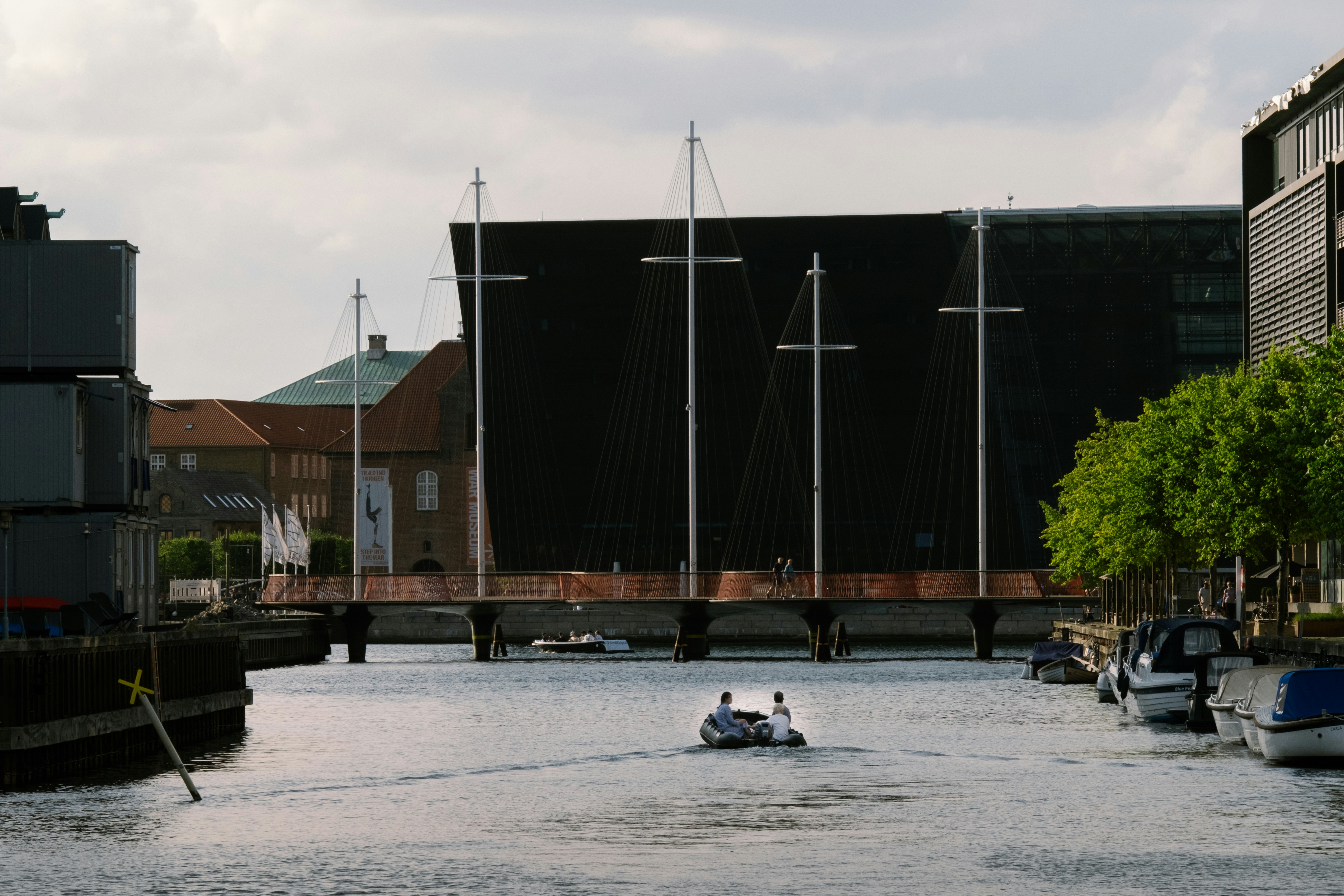 Mast-Bridge Quiet: A Tiny Boat Traverses the City Canal
