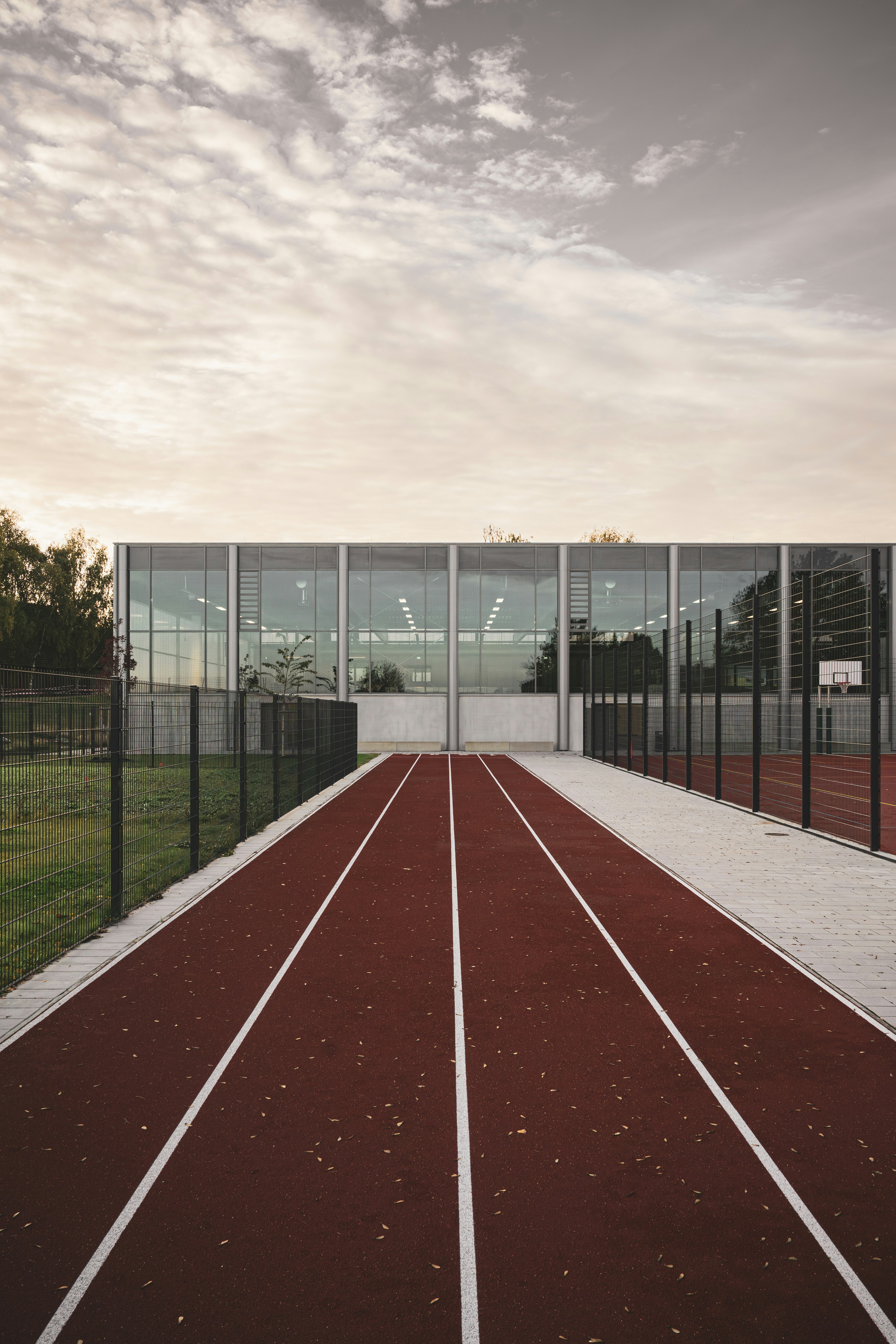 A long running track with a building in the background photo – Free ...