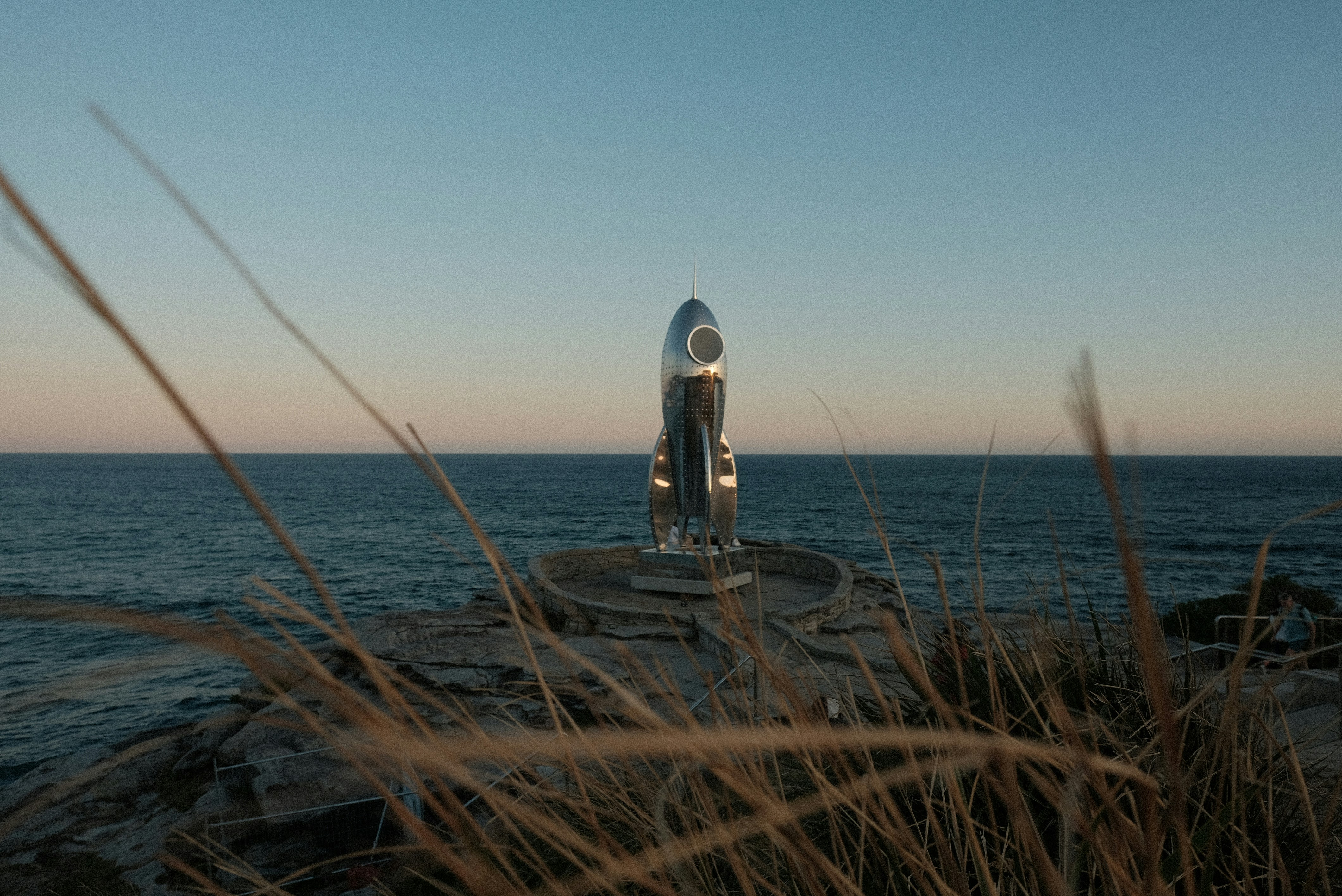 Lighthouse of Light: a solitary rocket sculpture framing the sea at dusk