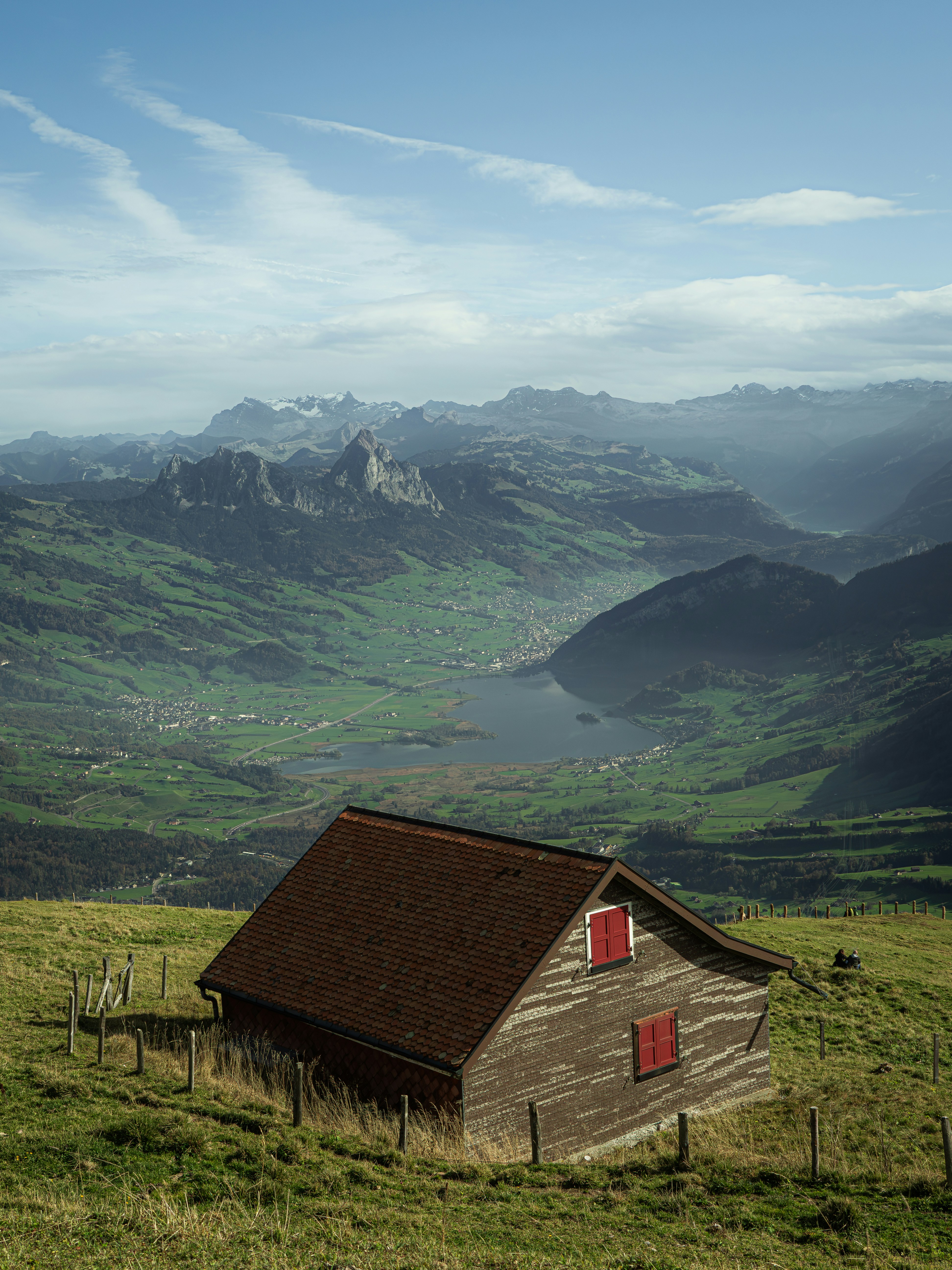 Hillside Cabin with Red Shutters Over a Verdant Valley