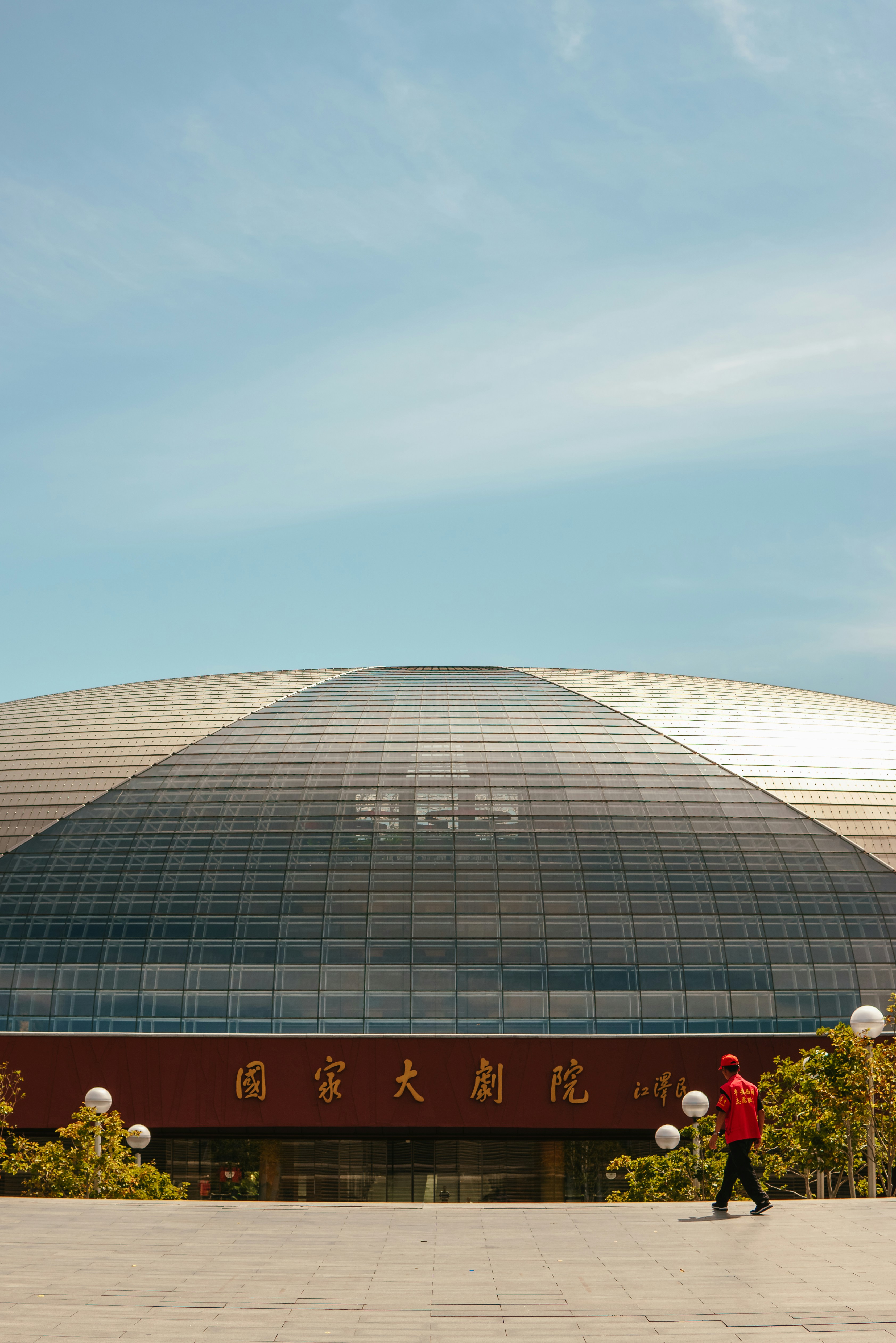 A man walking in front of a large building photo – Free Beijing Image ...
