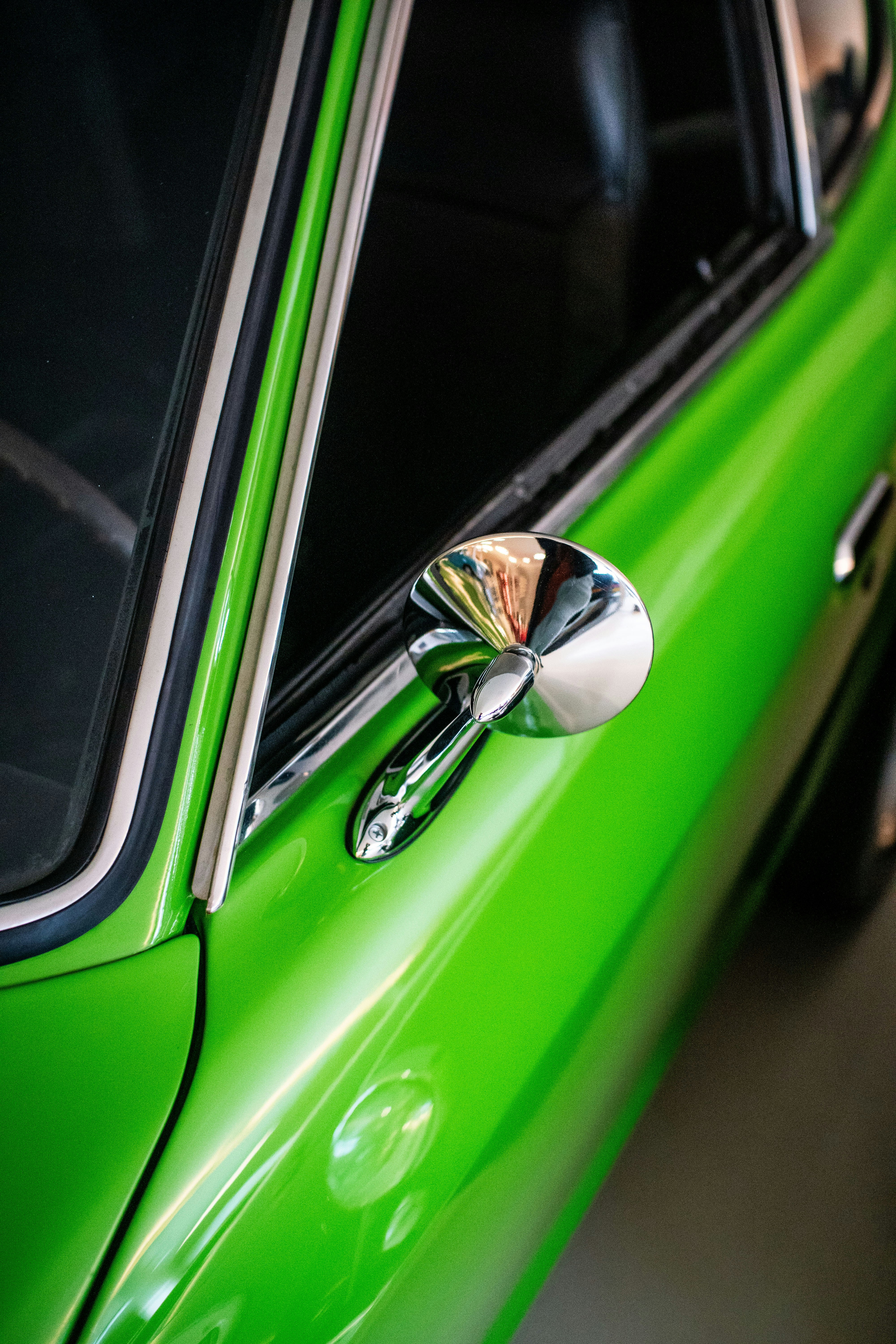 Verdant Chrome Reflection: Close-up of a Lime Classic Car's Side Mirror