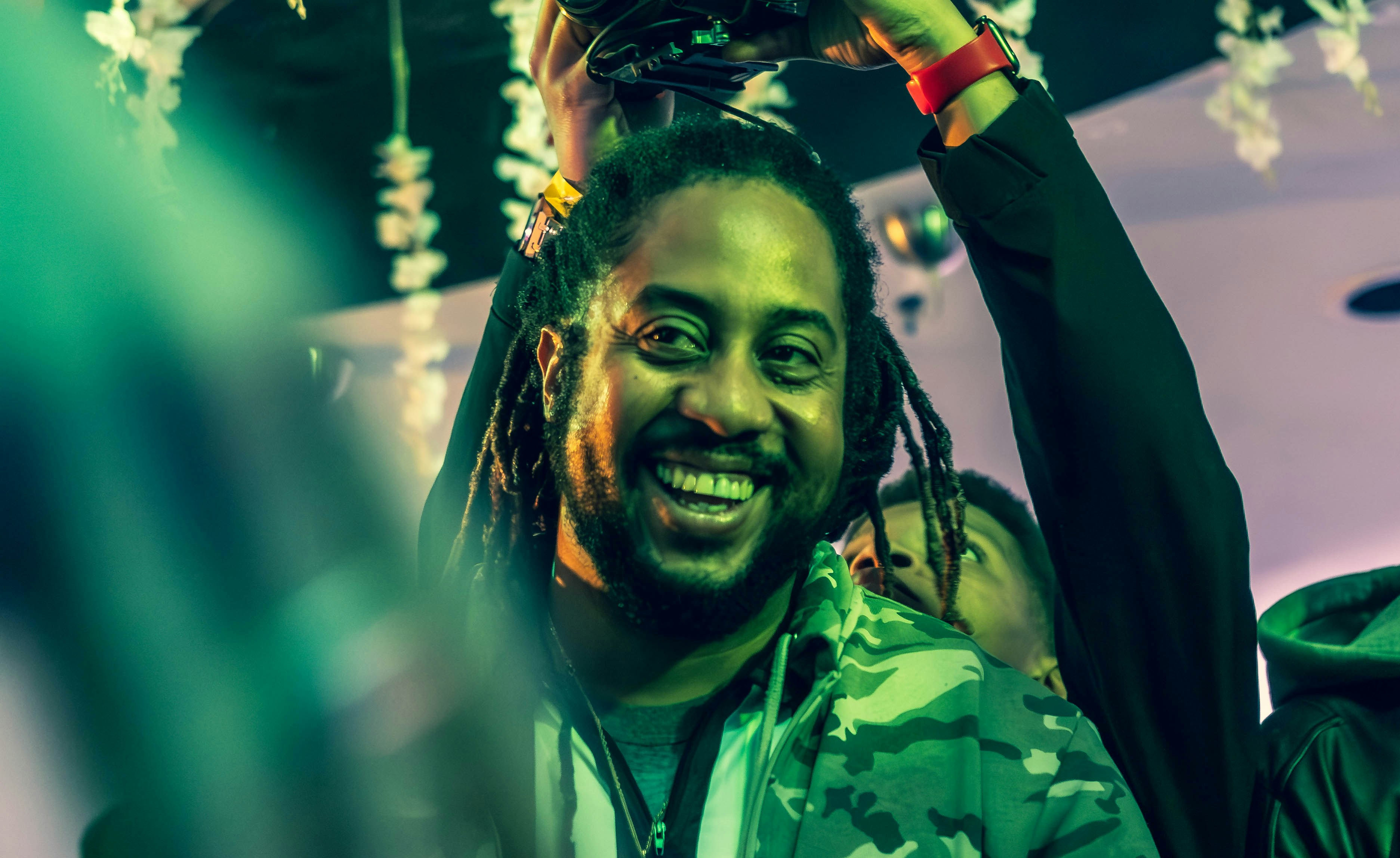 A man with dreadlocks holding a cell phone up to his ear photo – Free ...