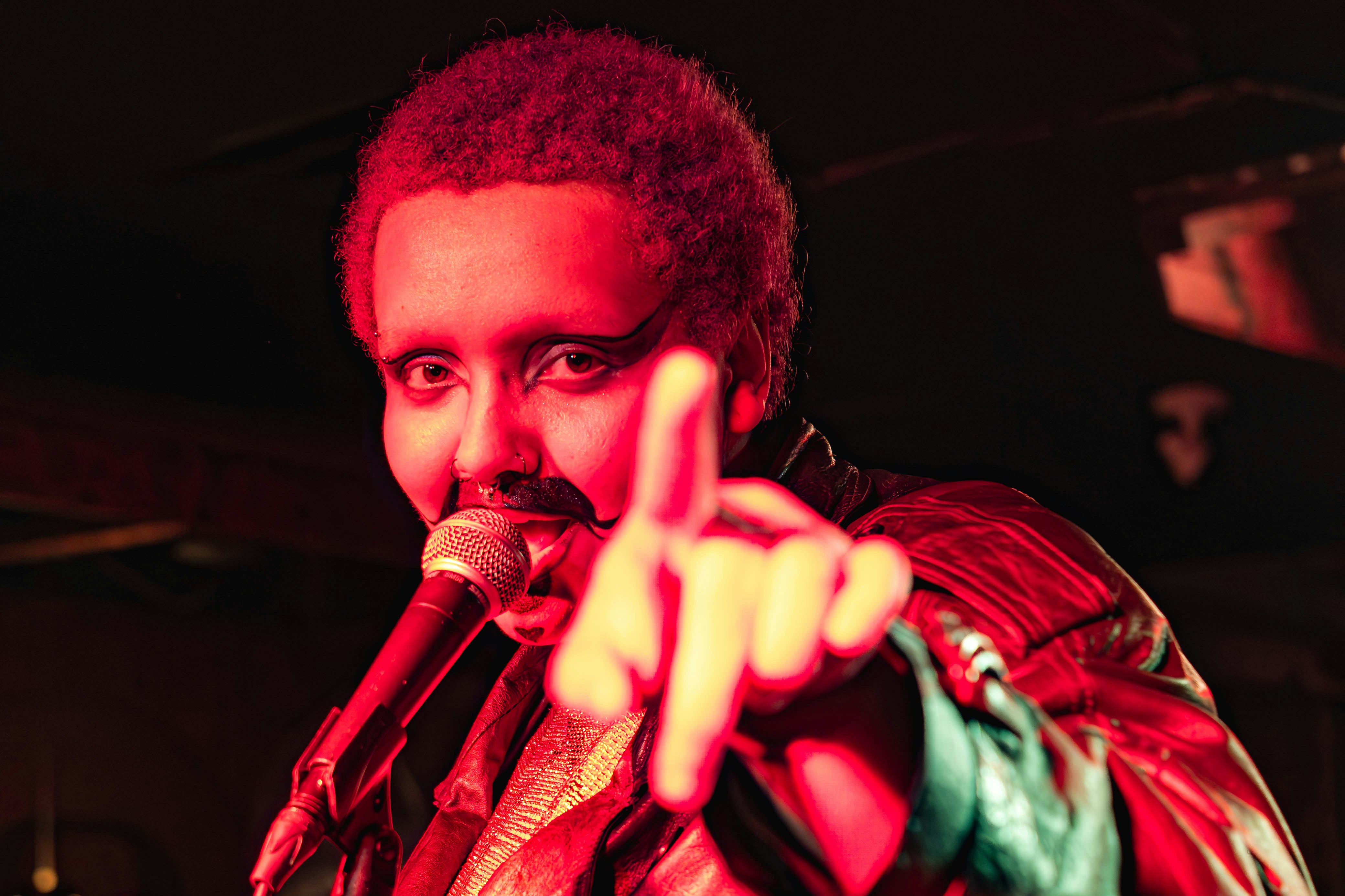 A man holding a microphone making a peace sign photo – Free Toronto ...