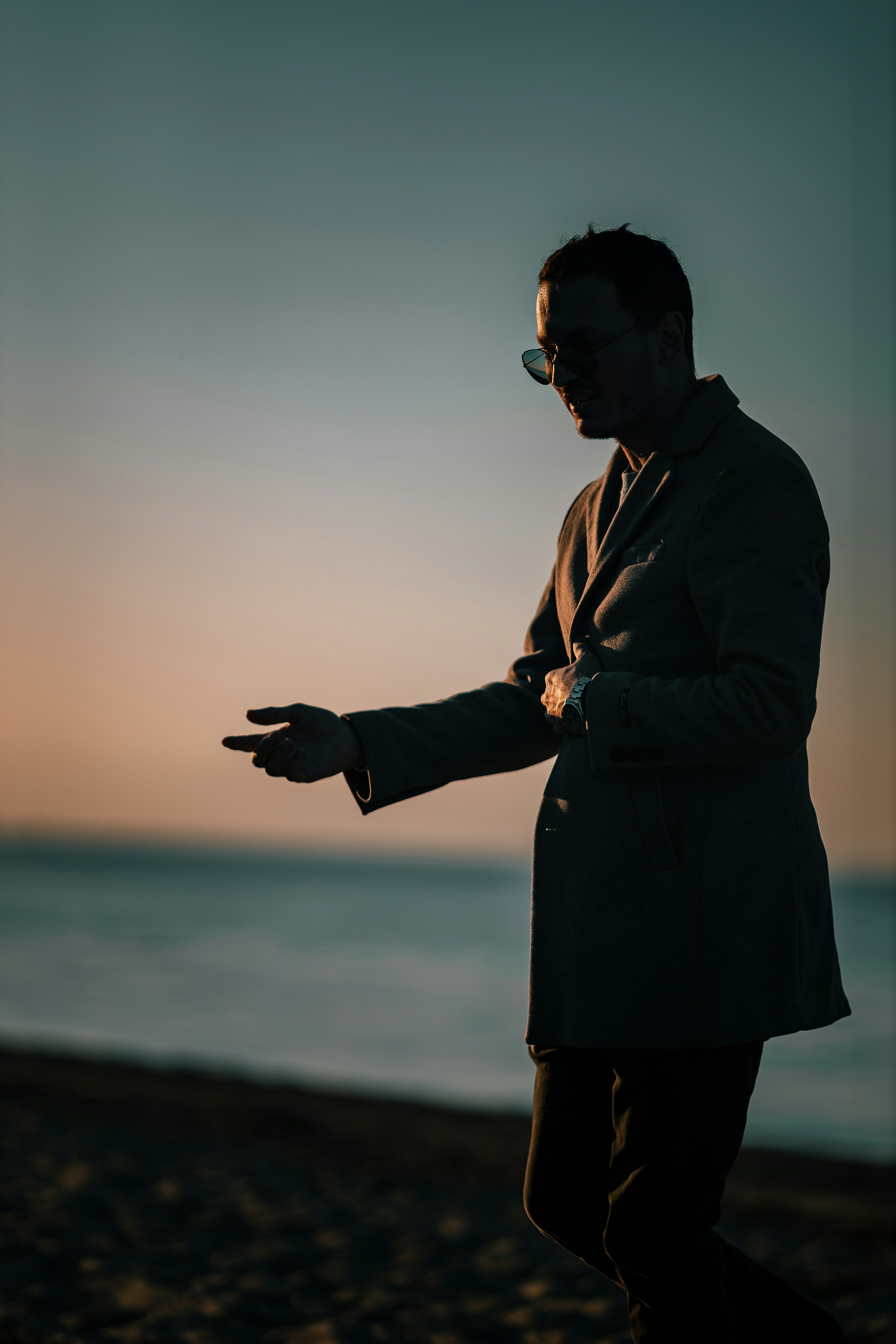 Silhouette of a Figure at Dusk: A Quiet Moment by the Sea