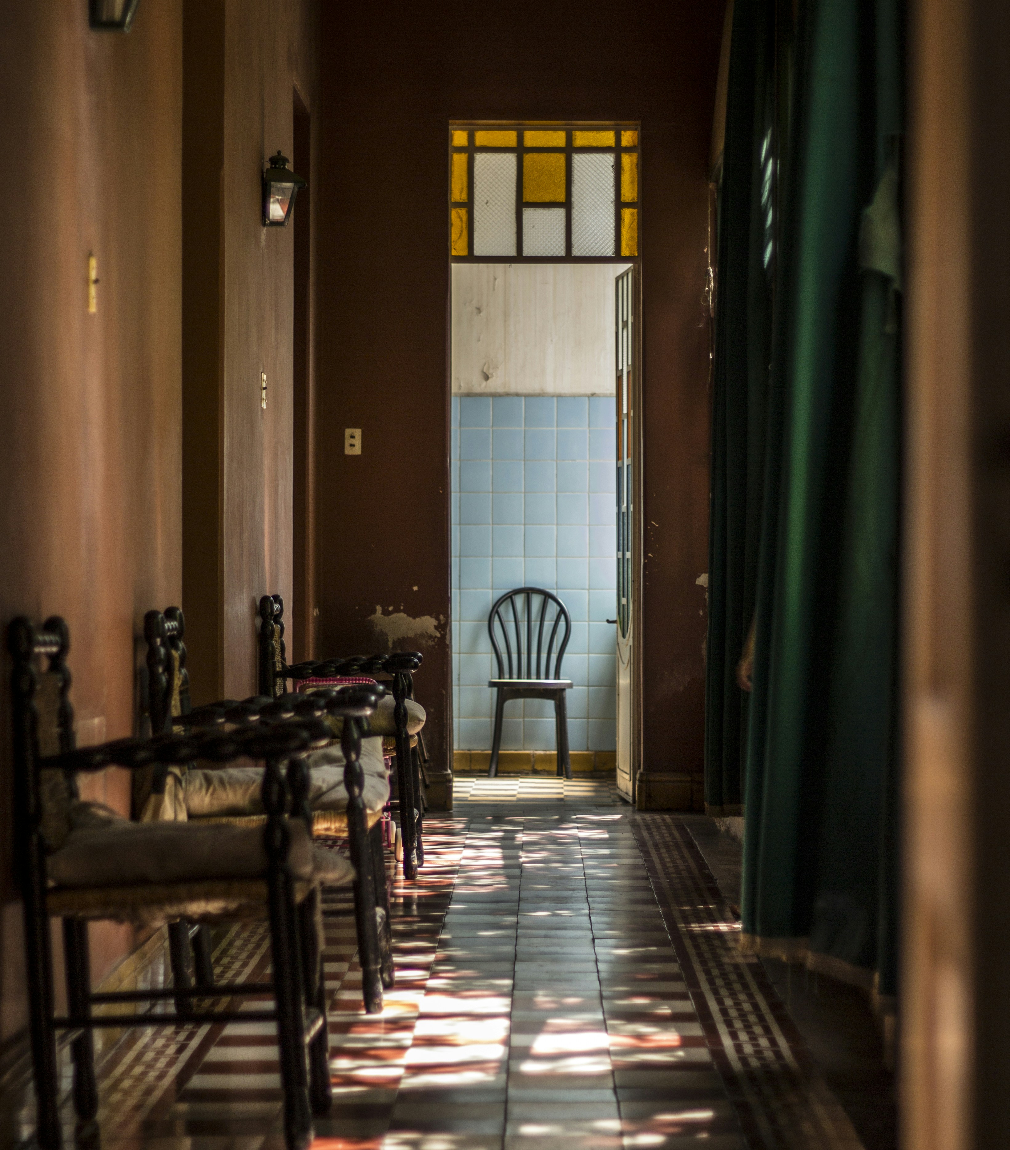 Threshold of Silence: The lone chair at the end of a sun-dappled corridor