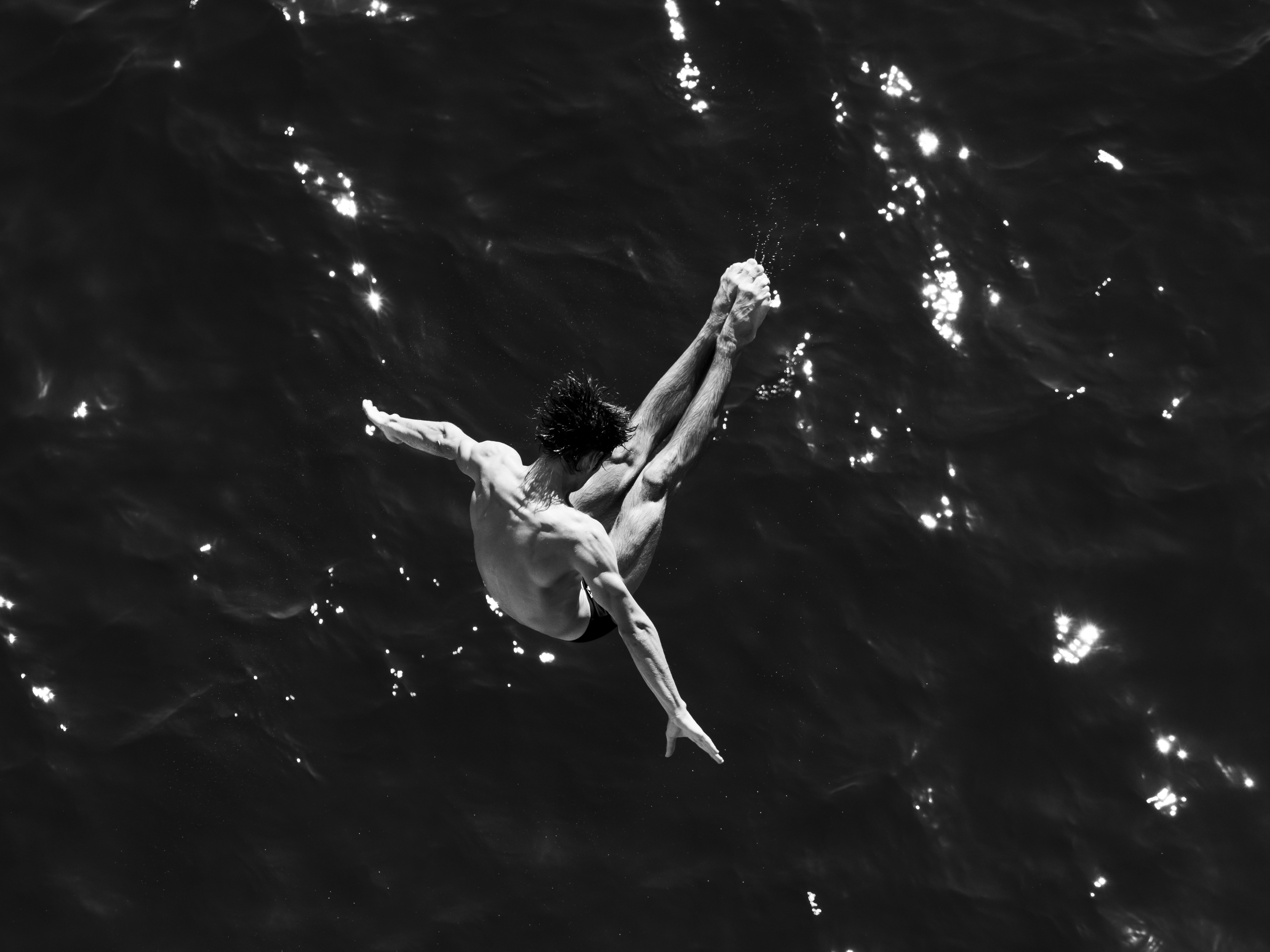 Midair Momentum: A Black-and-White Dive Over Quiet Seas