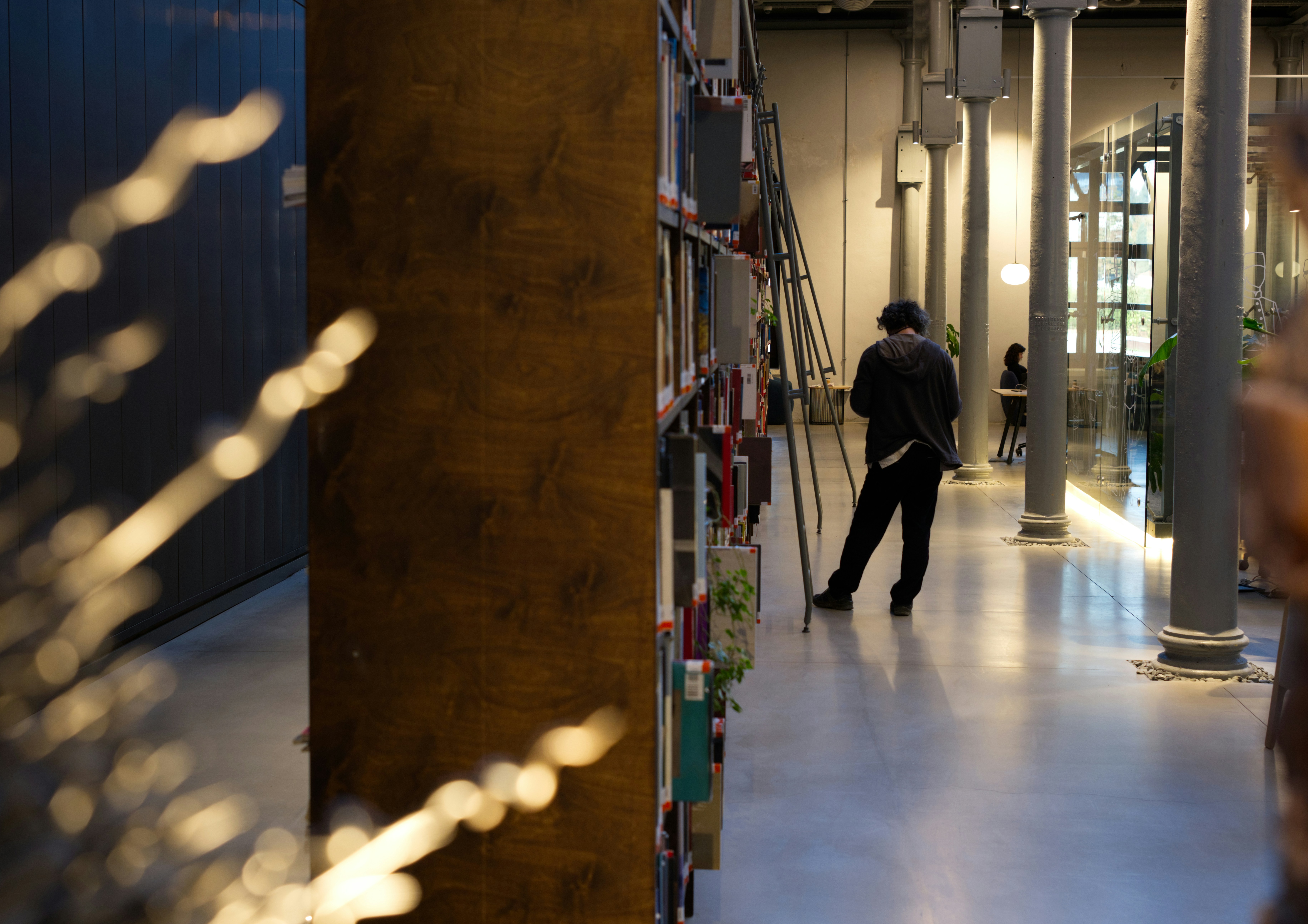 A man is walking down a long hallway