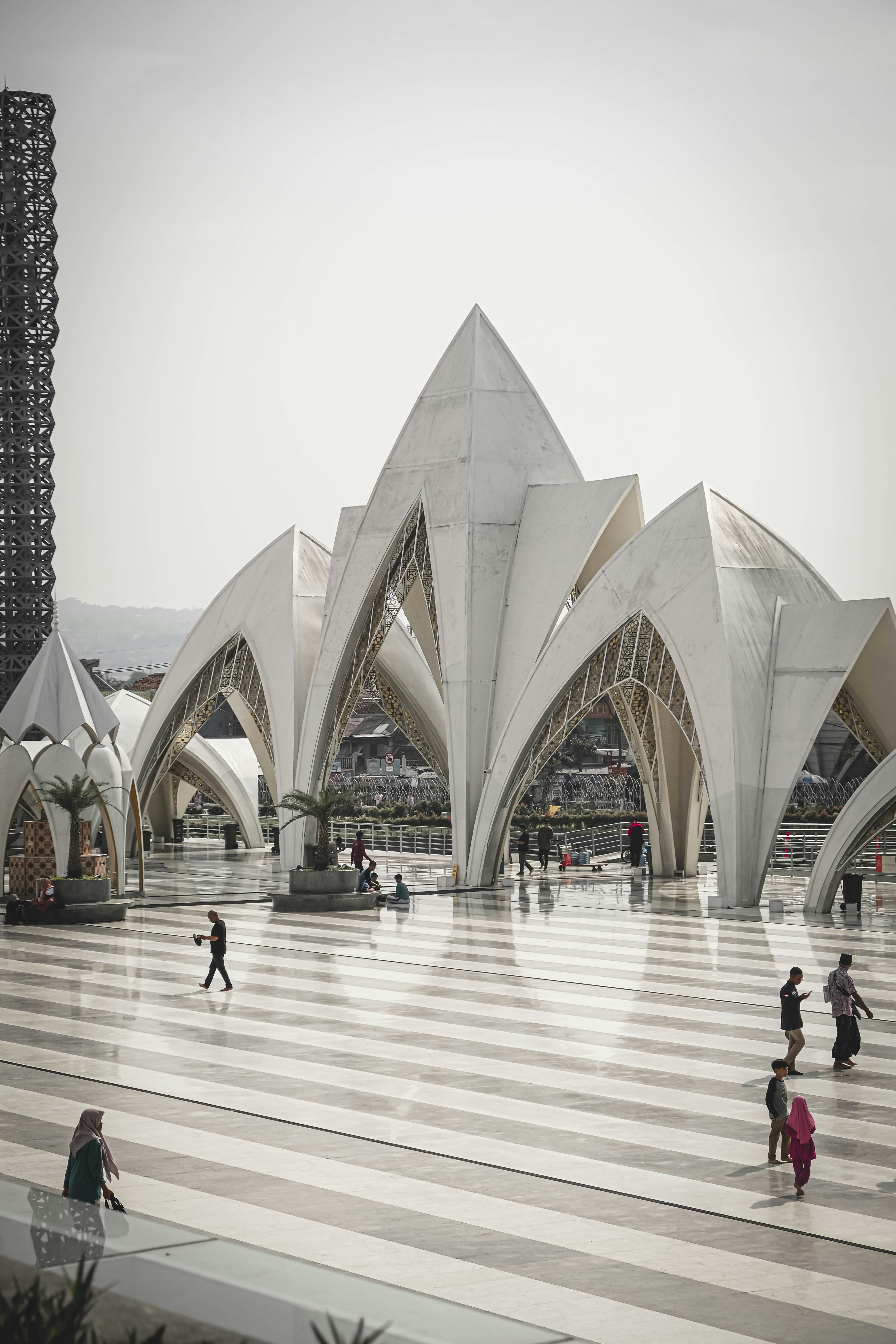 A group of people walking around a large building photo – Free Natural ...