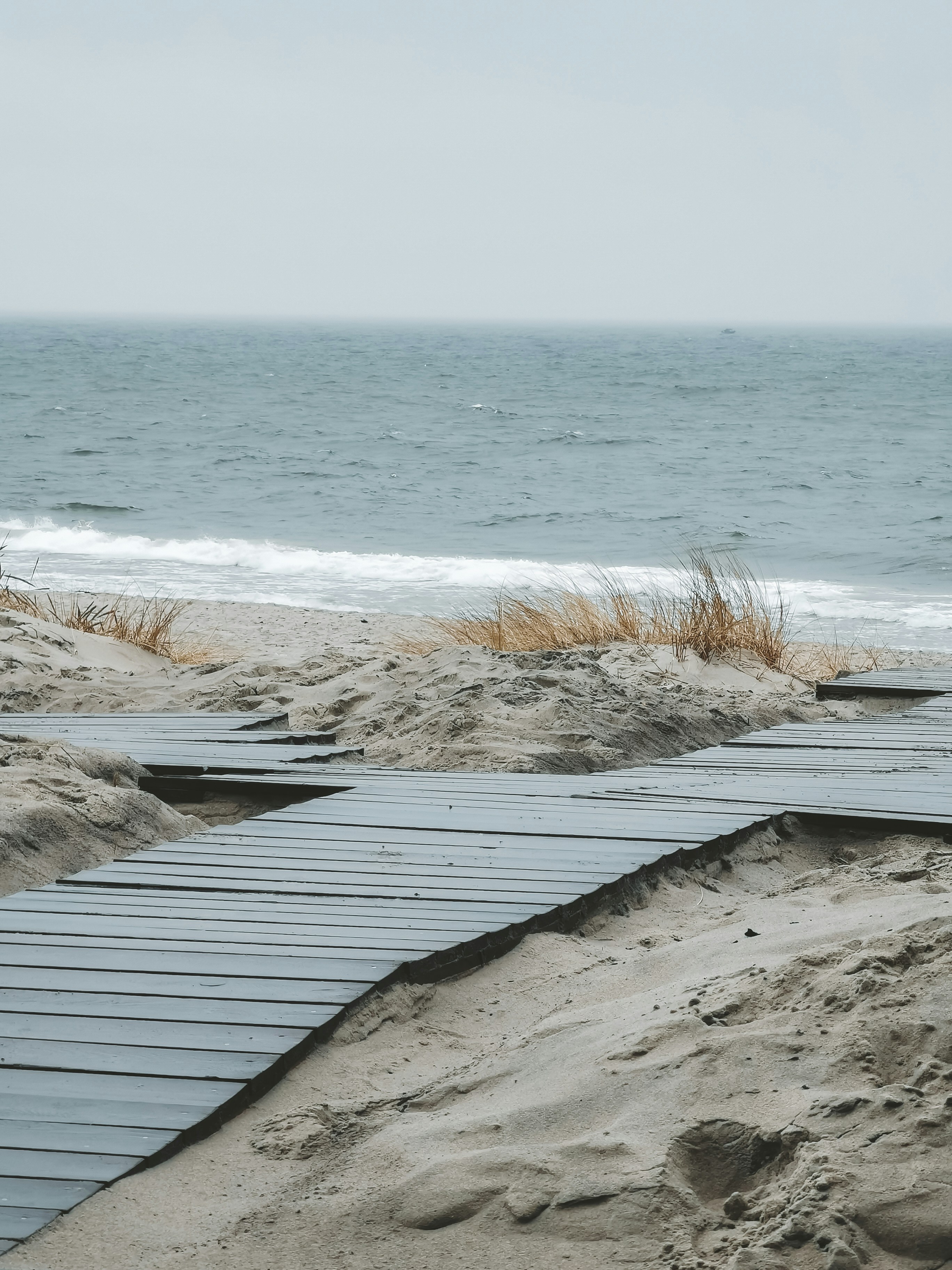 Boardwalk Through Wind-Swept Dunes Toward a Quiet Sea