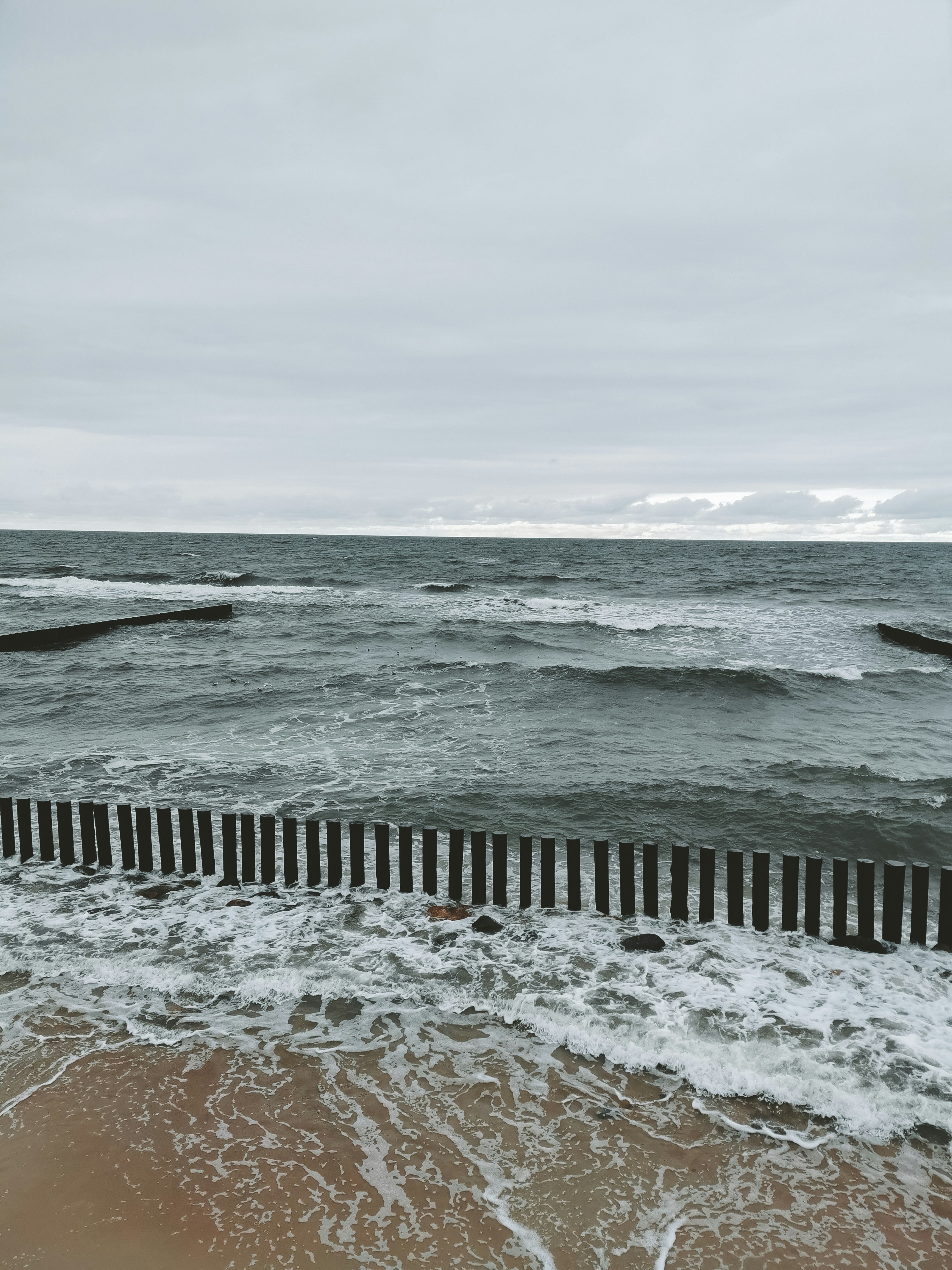 Groynes March Across a Gray Seascape Under a Brooding Sky