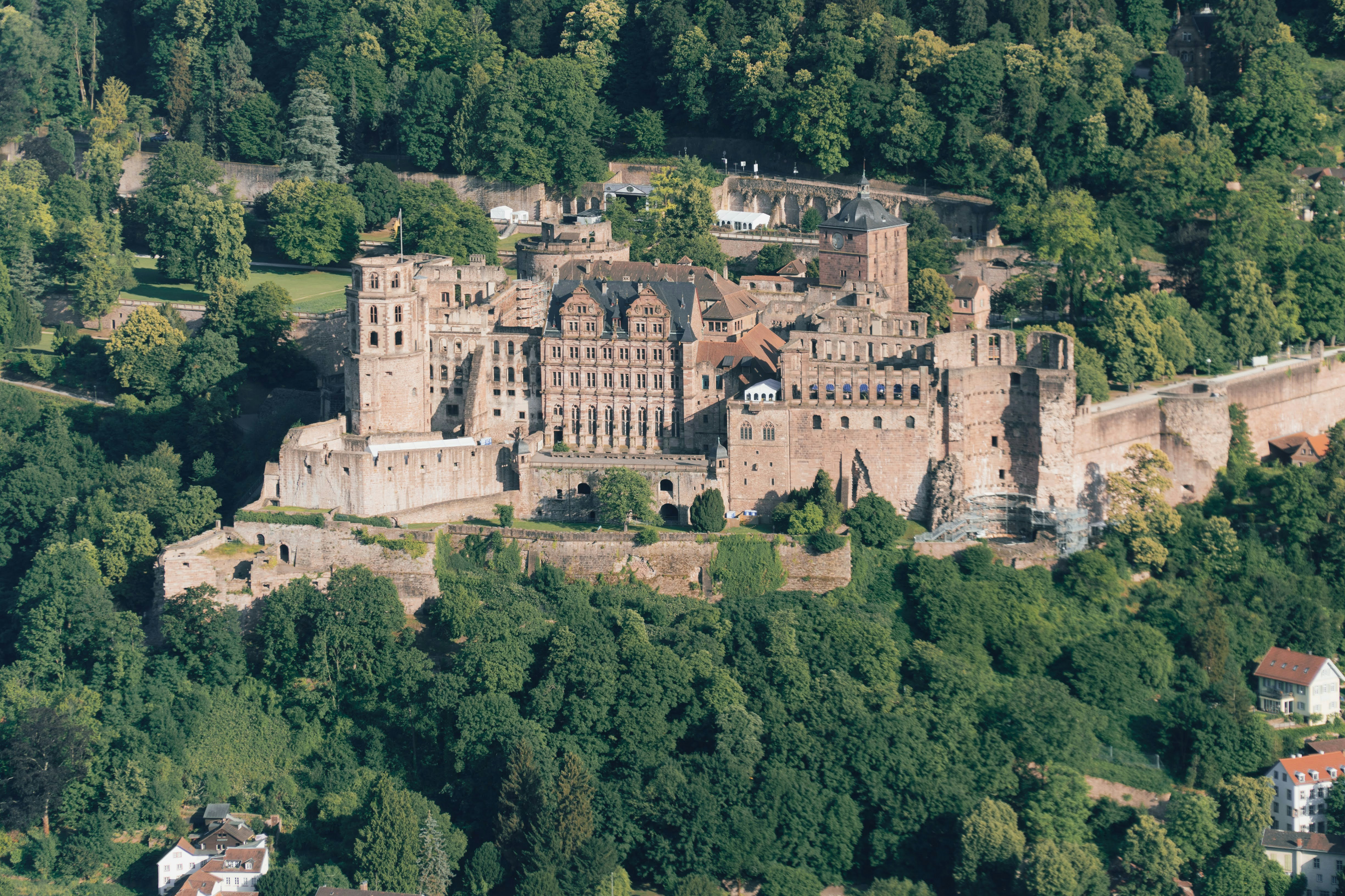 An aerial view of an ancient castle surrounded by lush green forests.