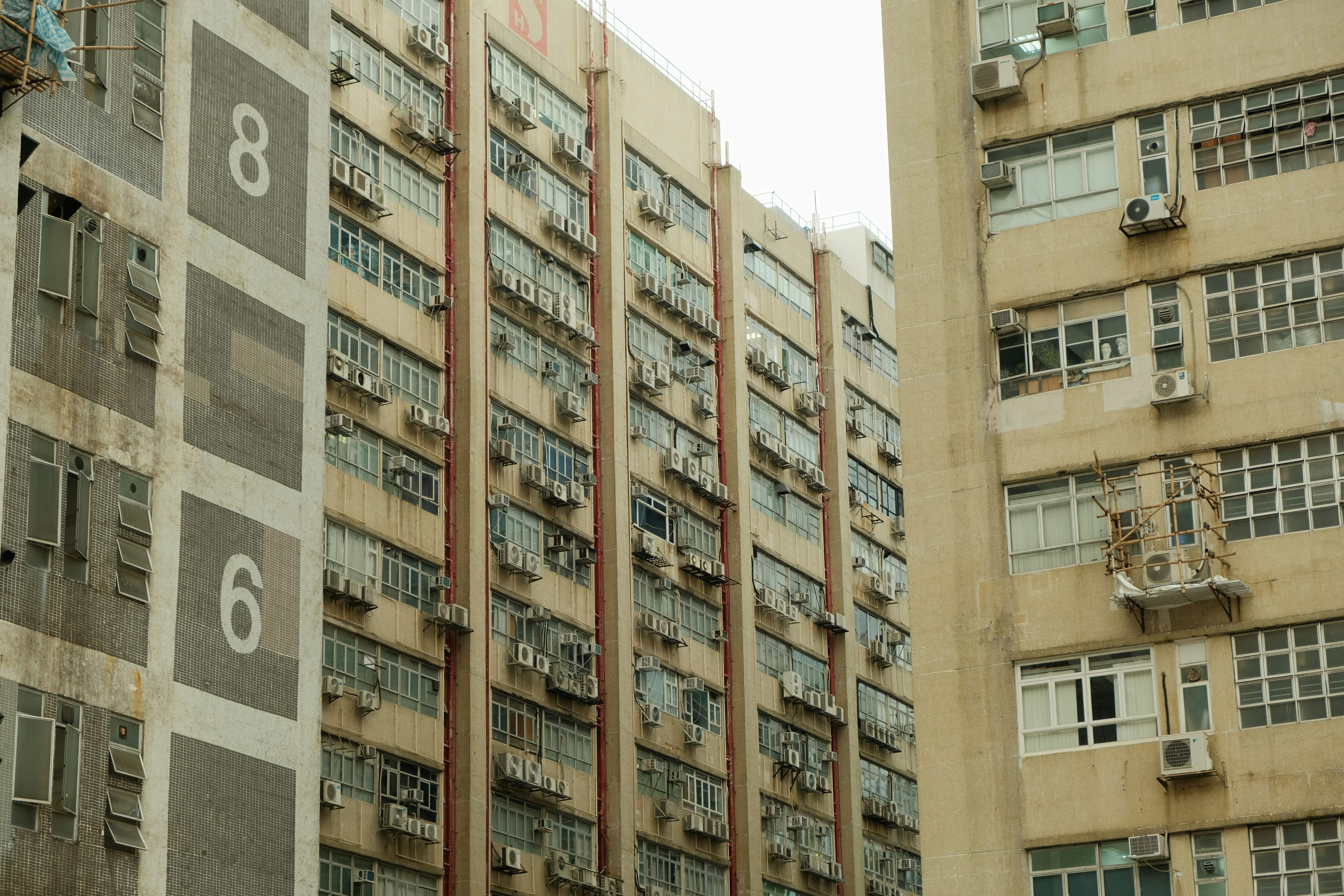 High-rise apartment buildings with numerous windows and external air conditioning units.