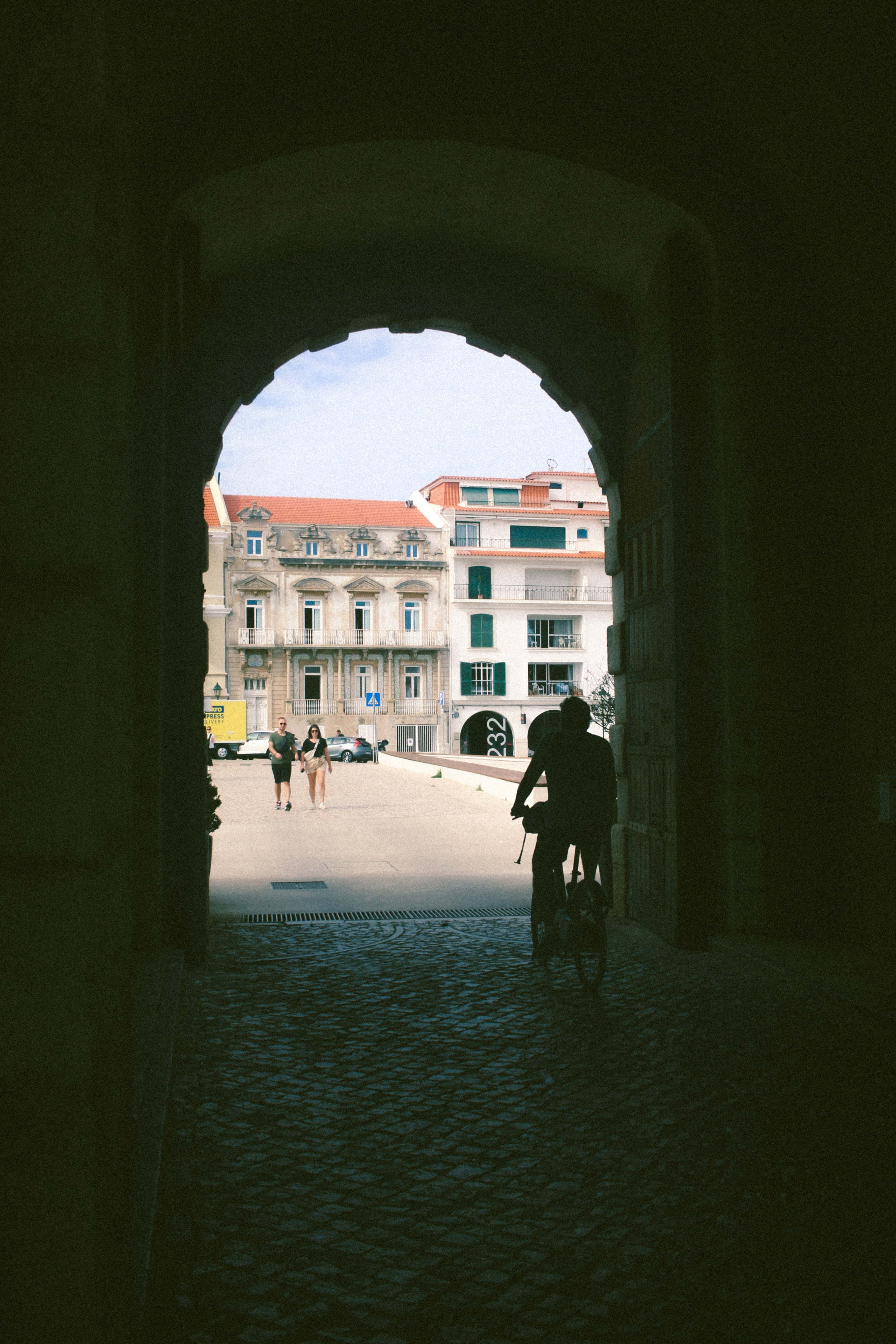 Through the Arch into Light: A Street Scene in Shadow