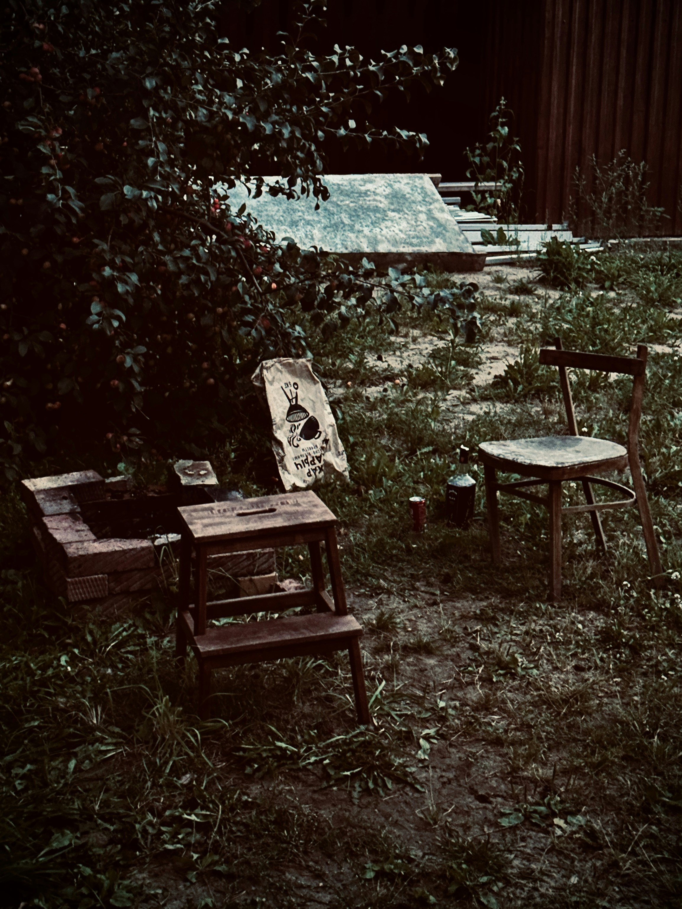 Dusky Backyard Still Life: Weathered Chairs and a Silent Bag