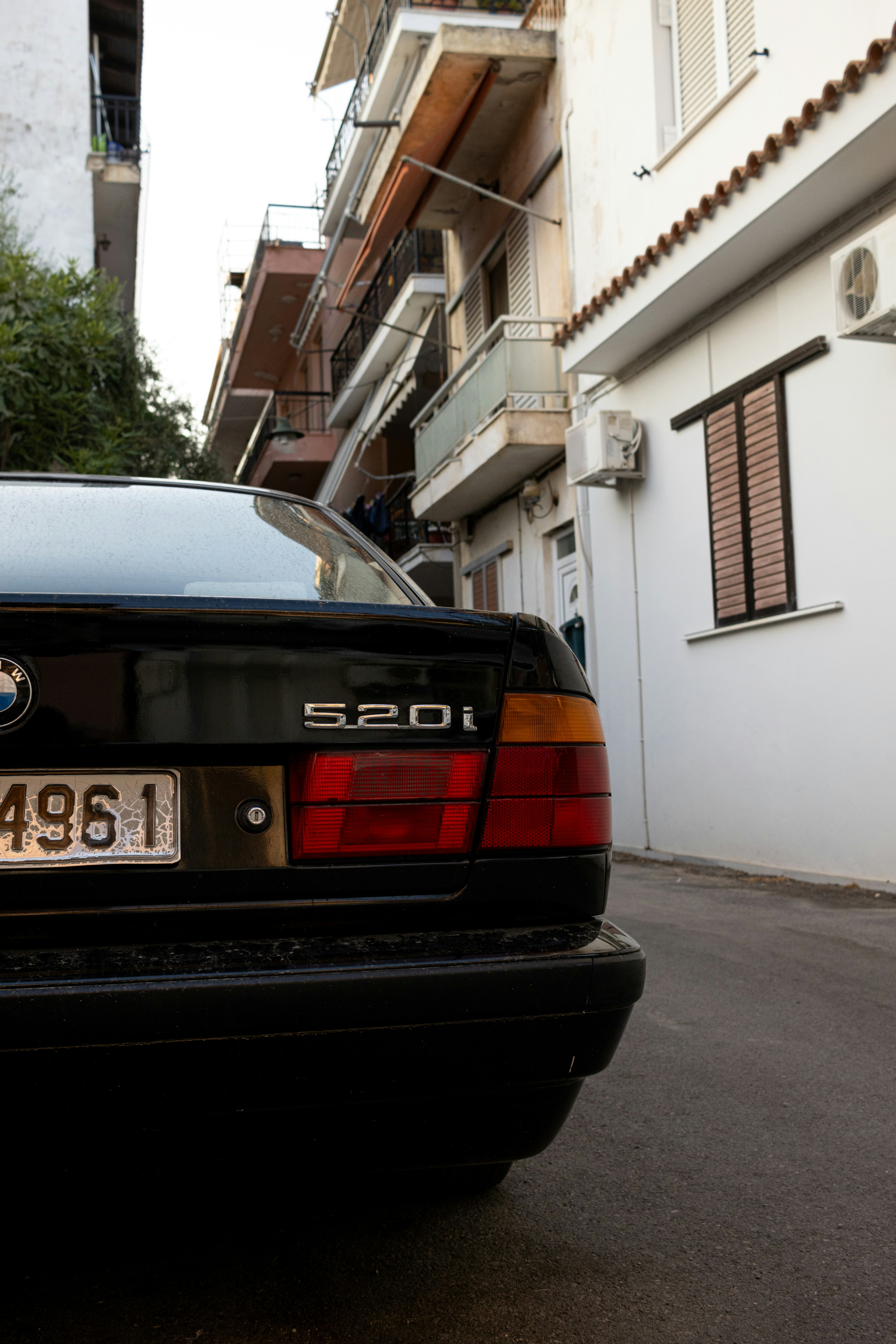Tail-Lighted Street Portrait: BMW 520i on a Narrow City Lane