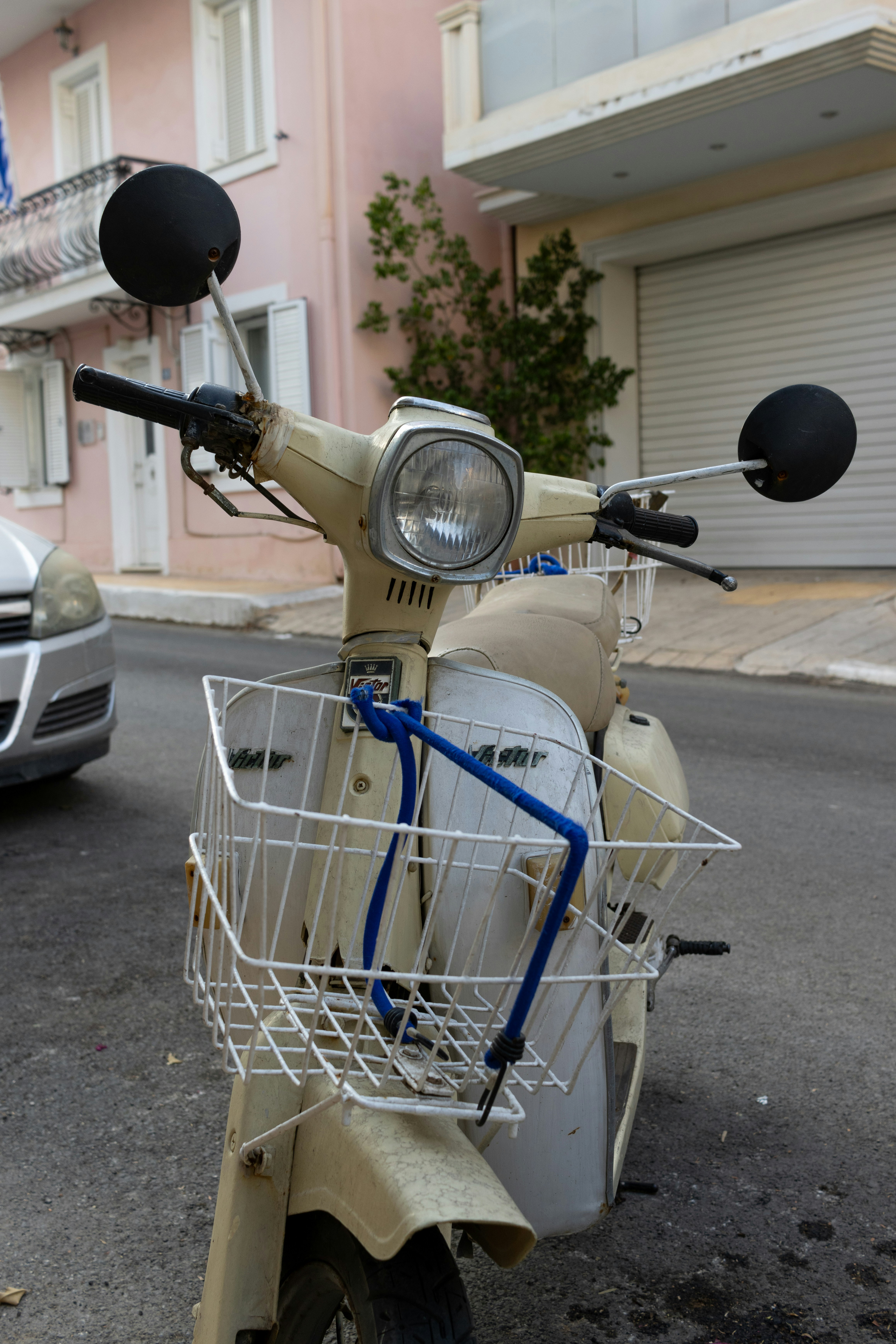 Beige Vintage Scooter Framed by a Pastel City Street