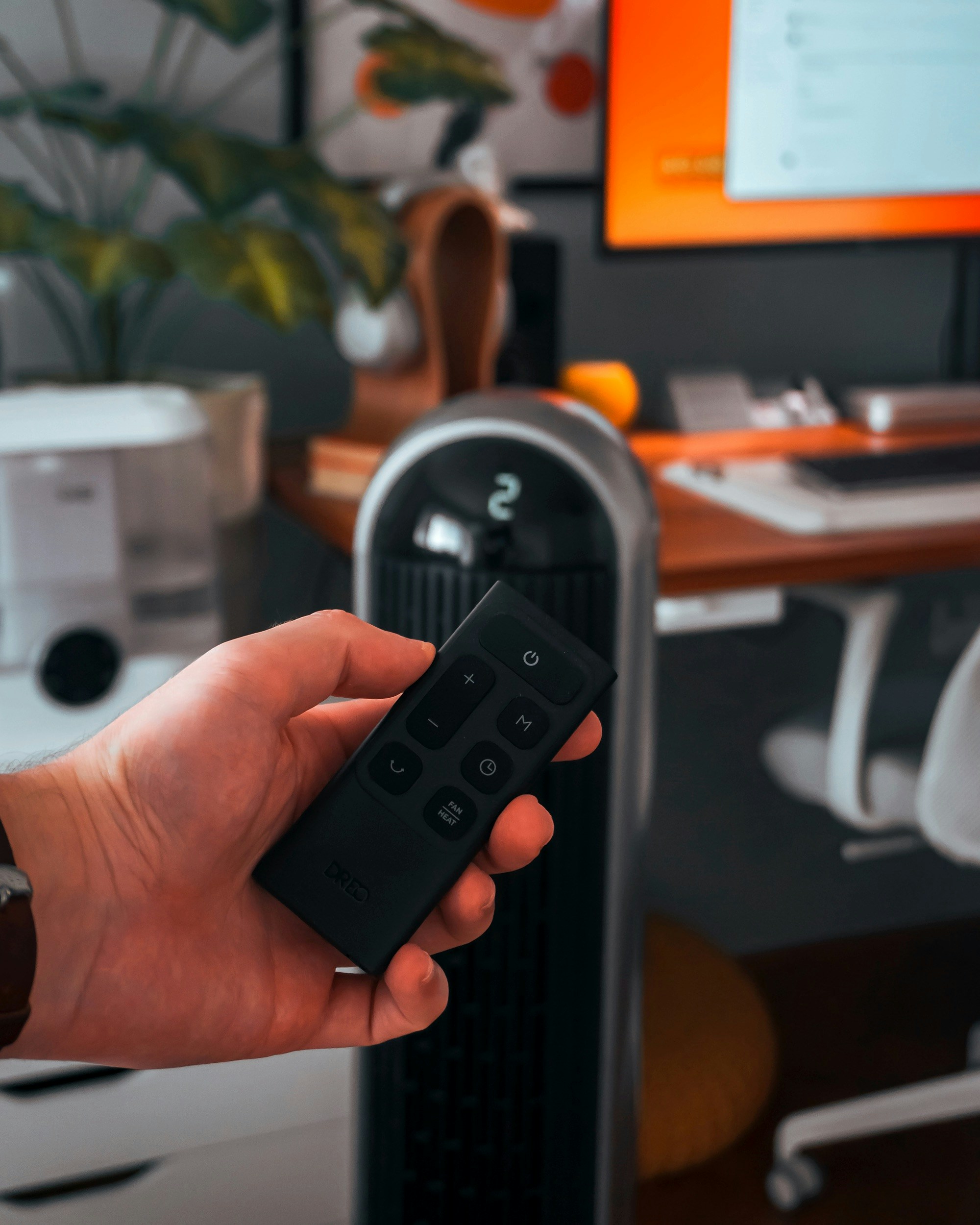 A person holding a remote control in their hand photo – Free Desksetup ...