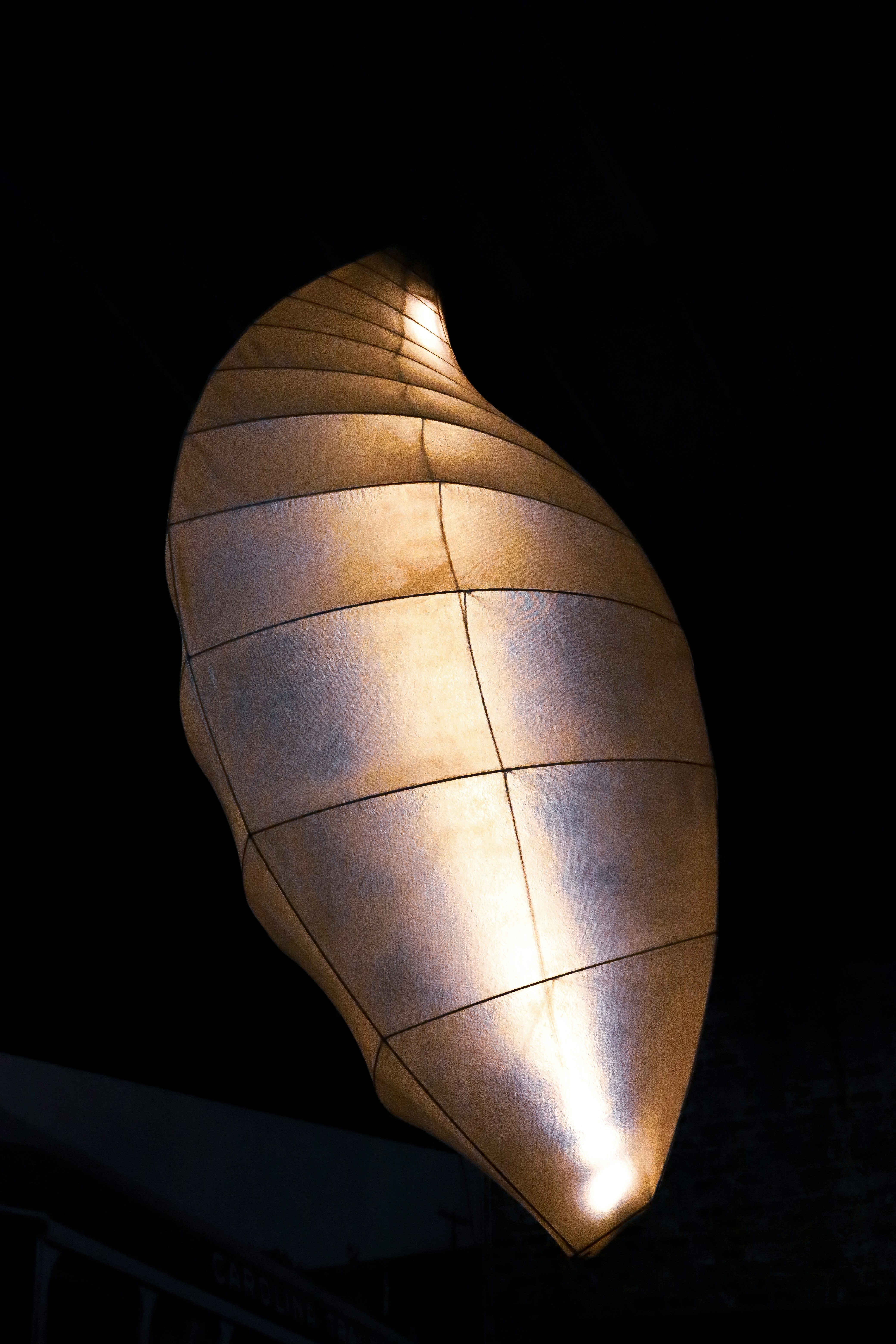 Amber Segmented Lantern Ascends from Darkness