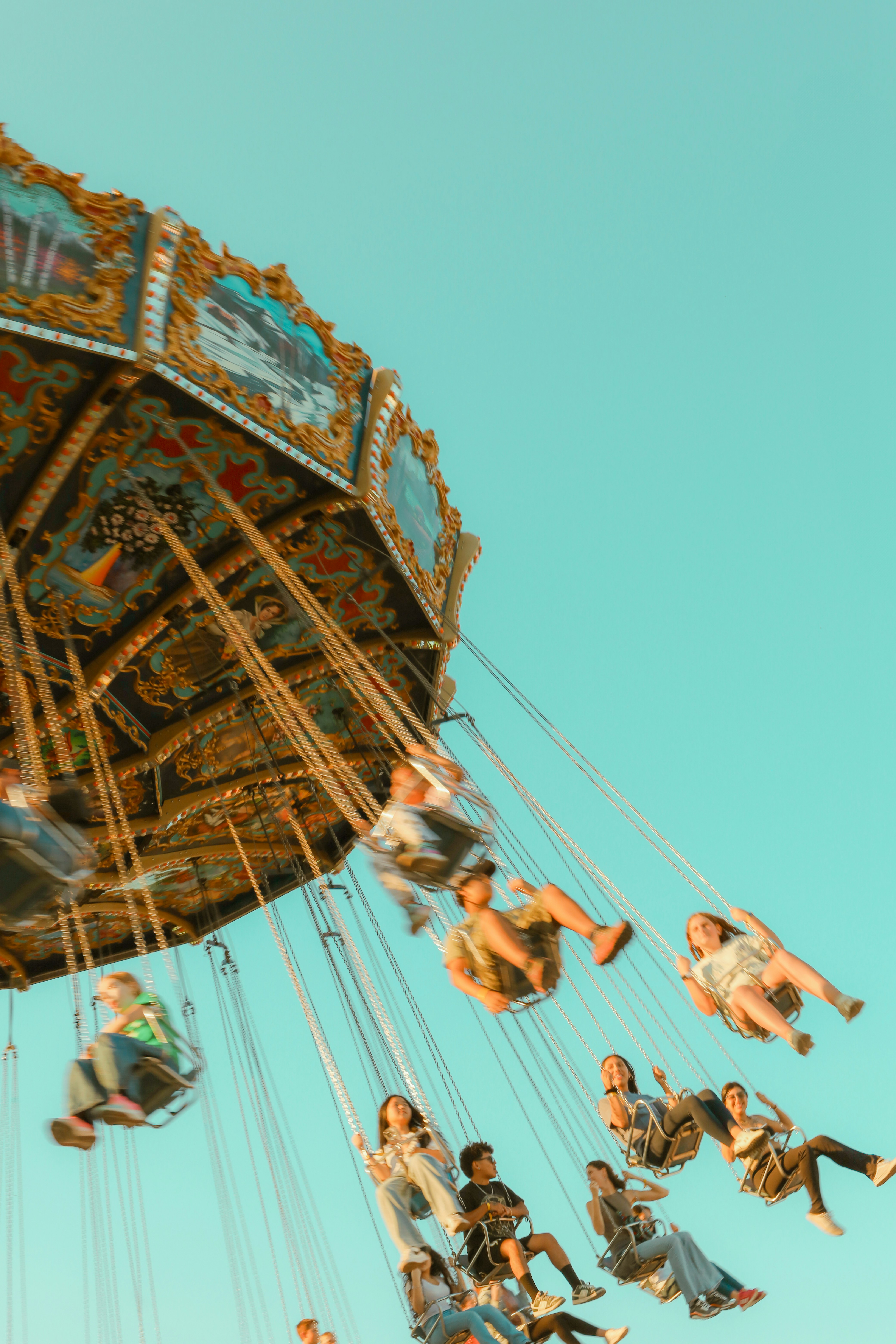 A group of people riding on top of a merry go round photo – Free Autumn ...