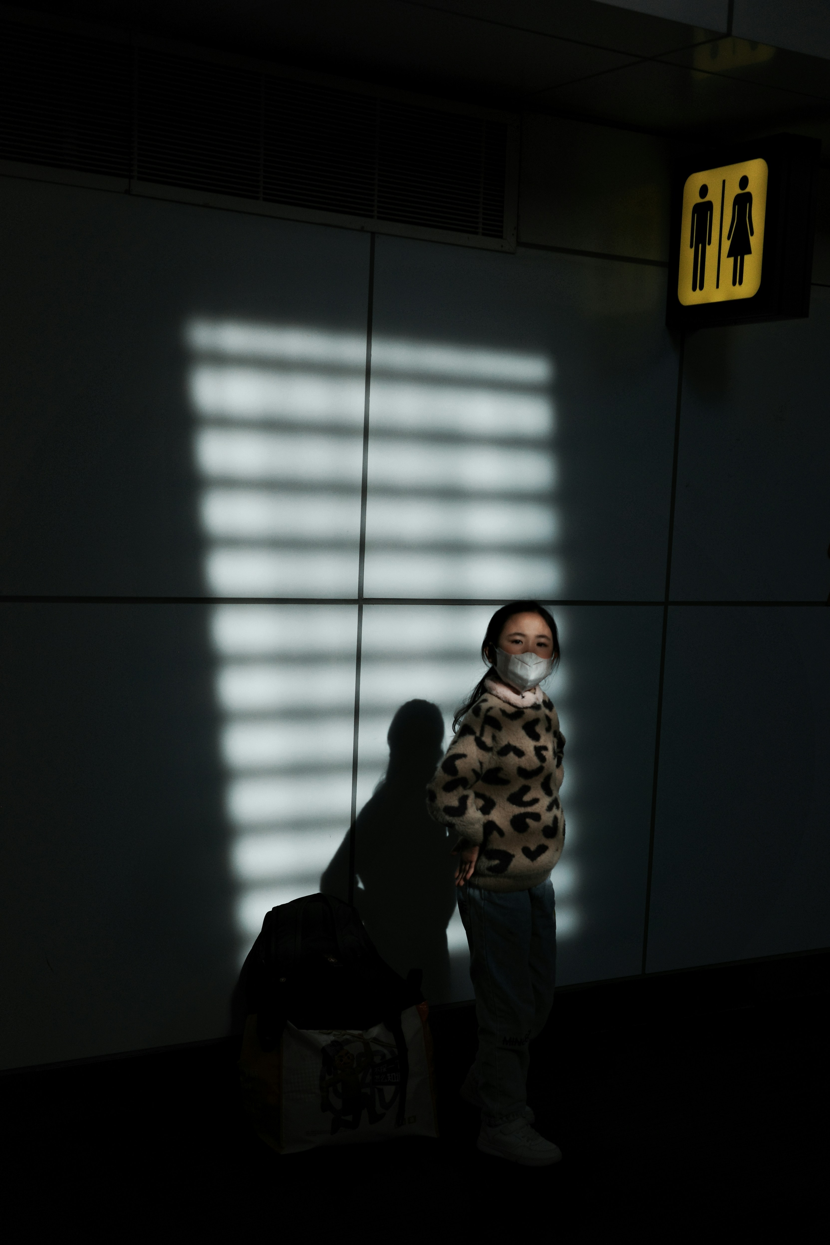 Leopard Knit in Striped Light: A Quiet Moment in a Dim Corridor