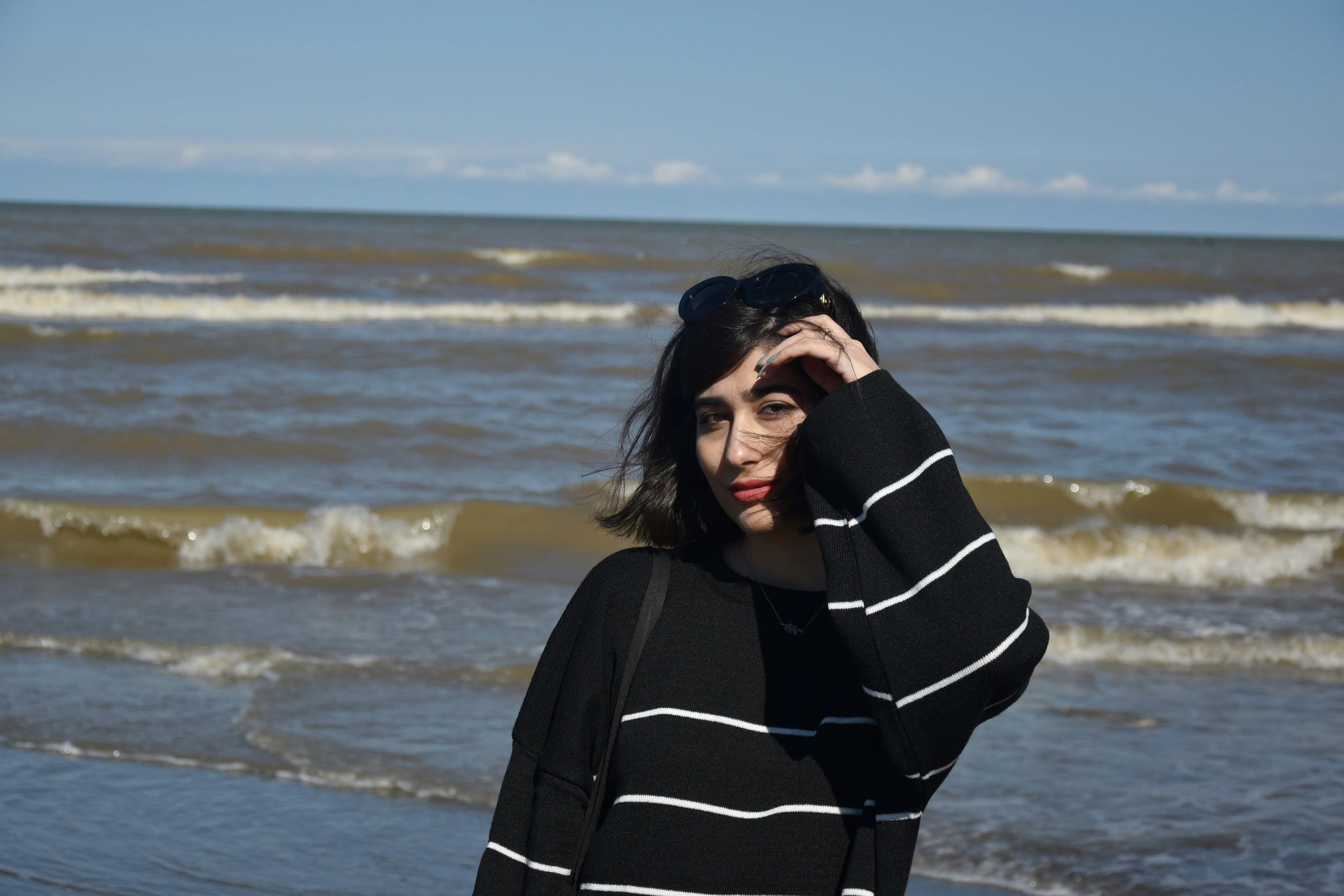 Stripes Against the Sea: a sunlit beach portrait by the breakers
