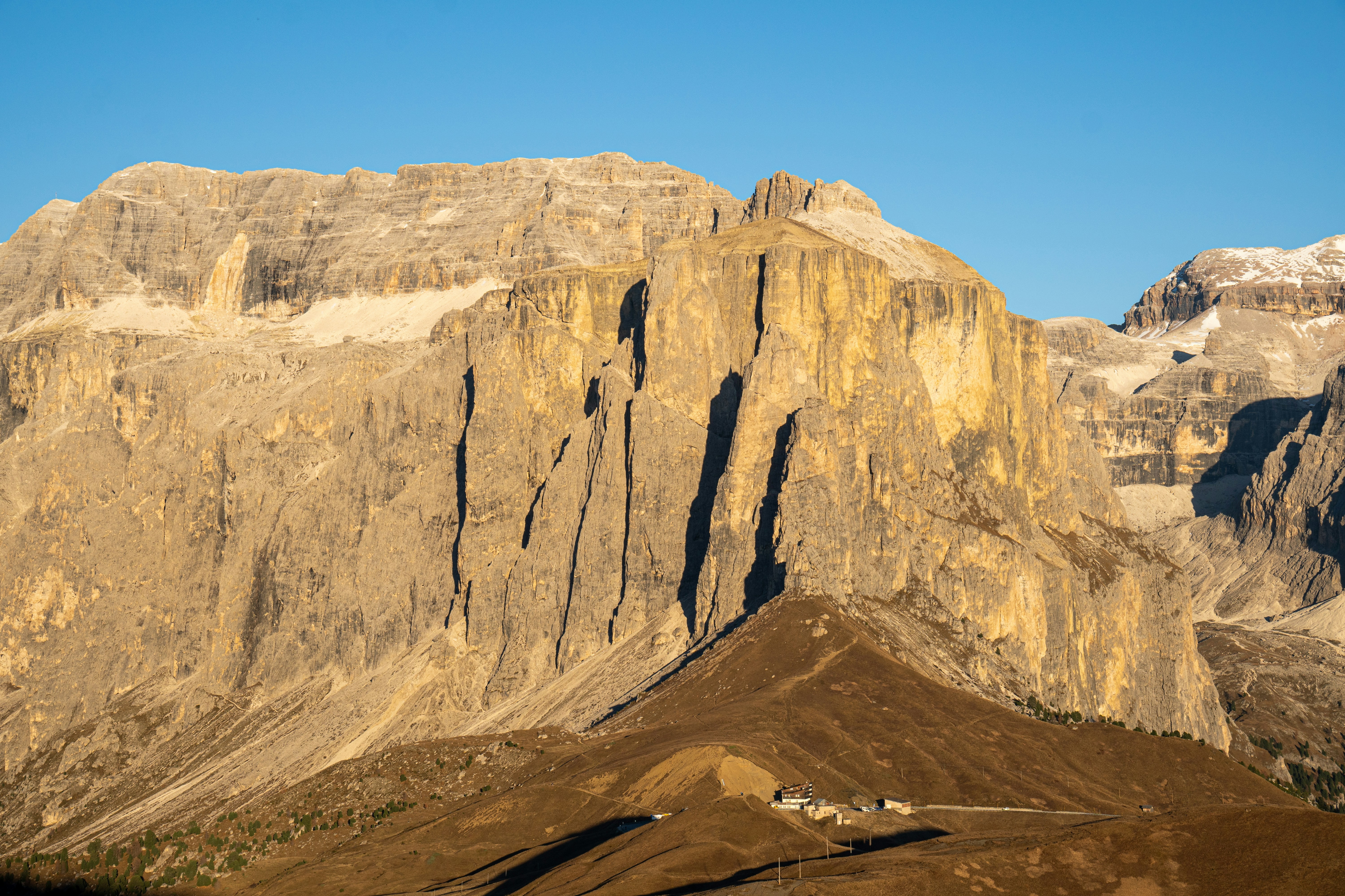 Sunlit Facade: A Towering Cliff Above a Quiet Moor