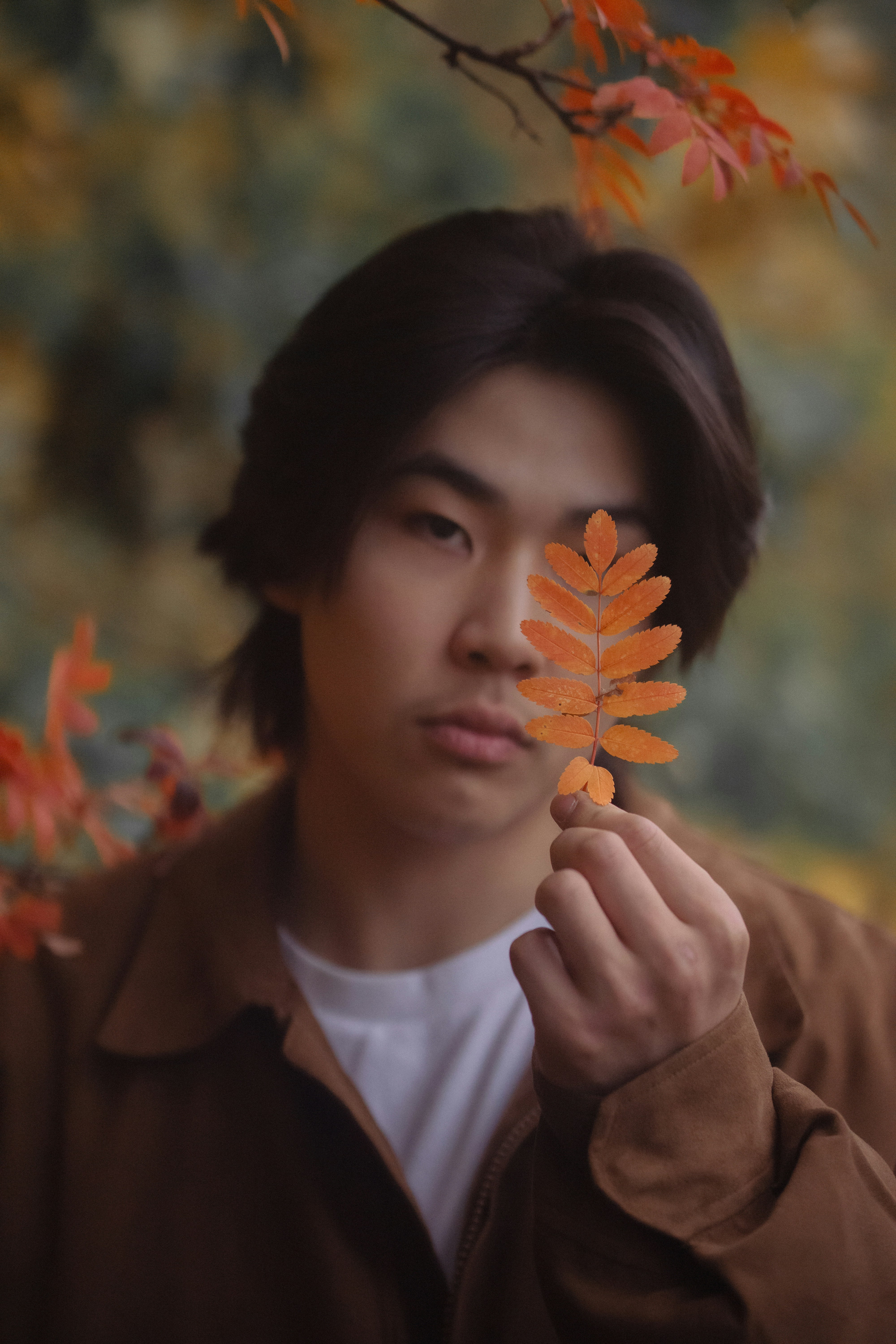 Autumn Whisper: Holding a Leaf Against a Blurred Portrait