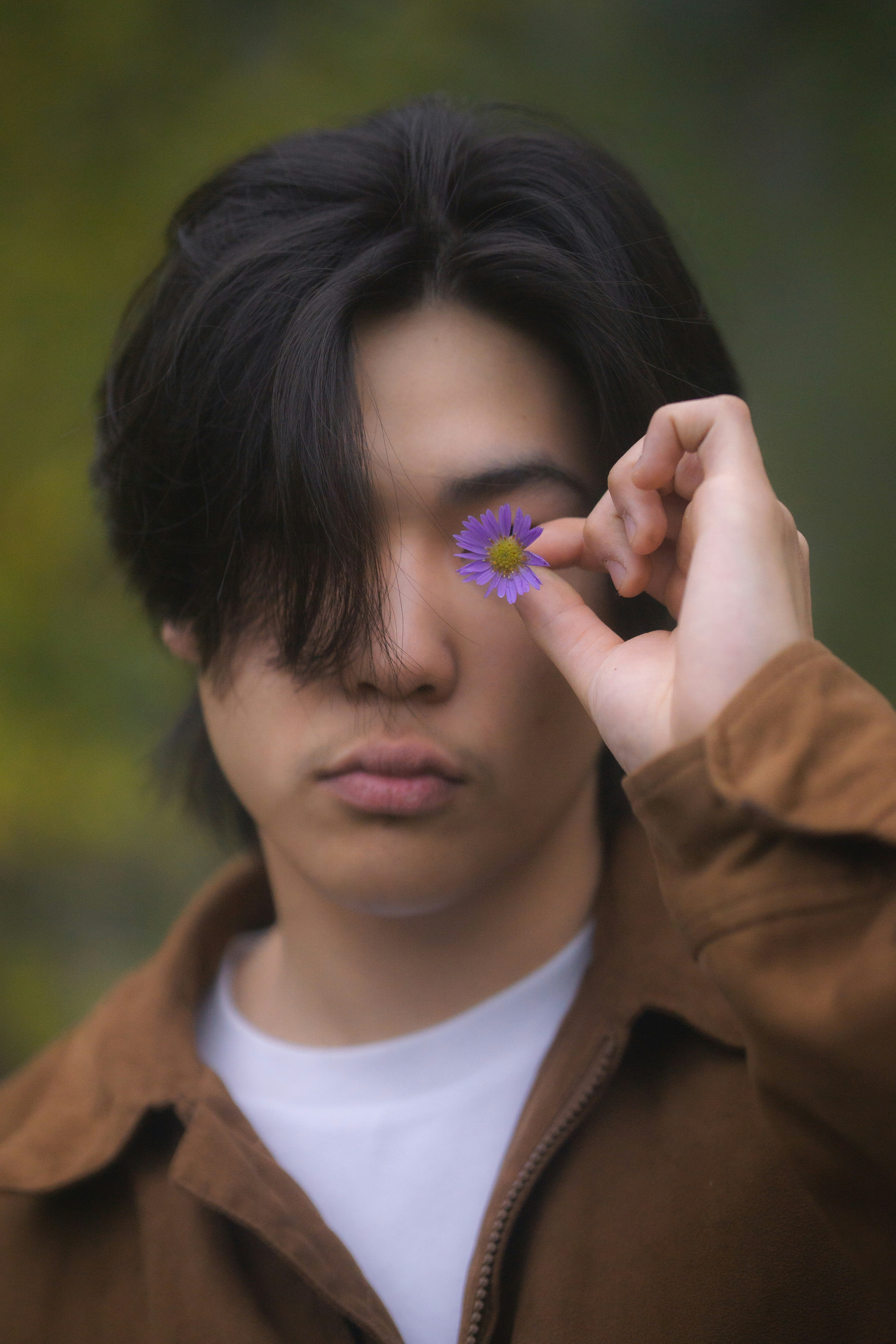 Whisper of Violet: A Portrait Framed by a Handheld Bloom