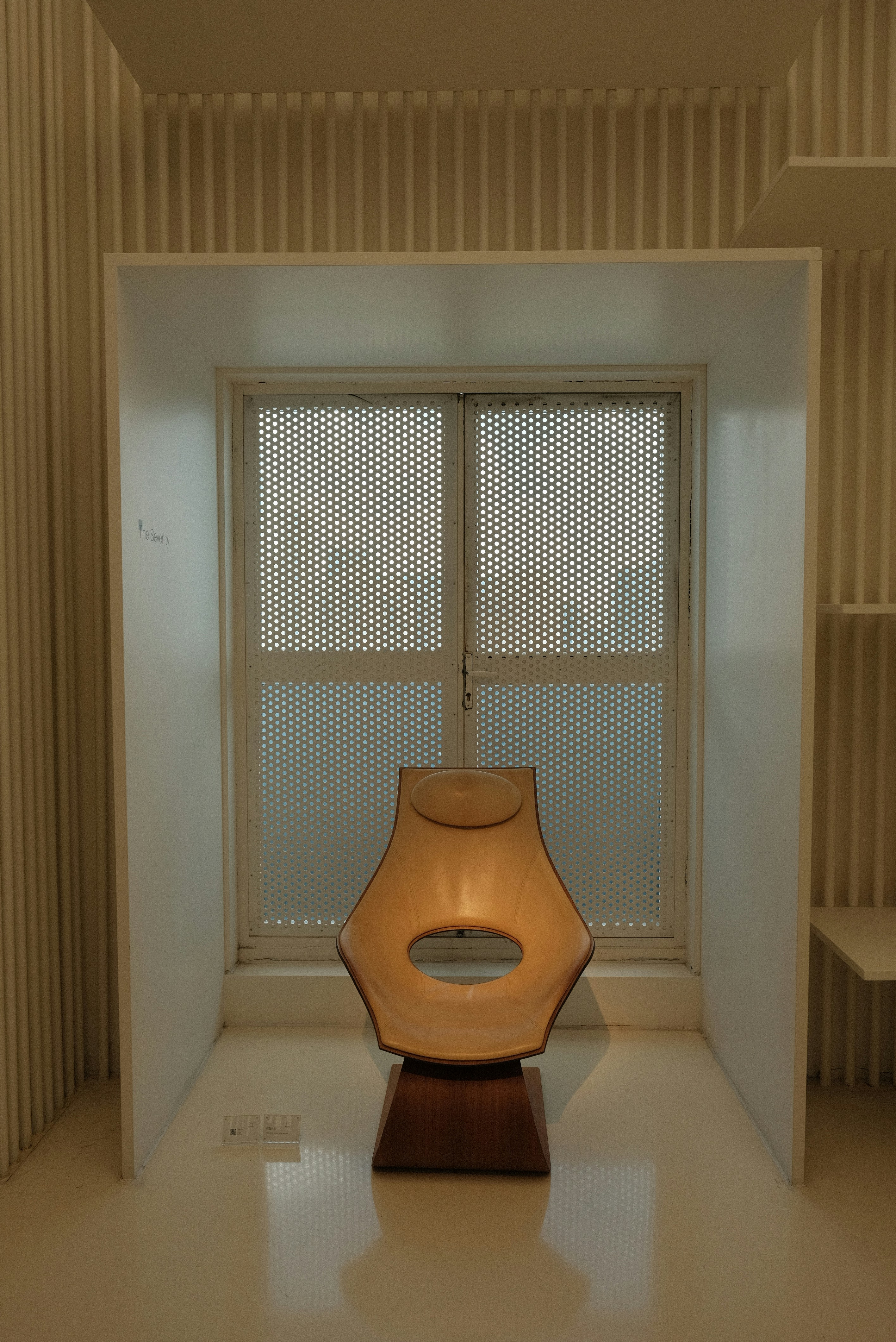 Centerpiece in Quiet Geometry: A Sculptural Chair Framed by Perforated Light