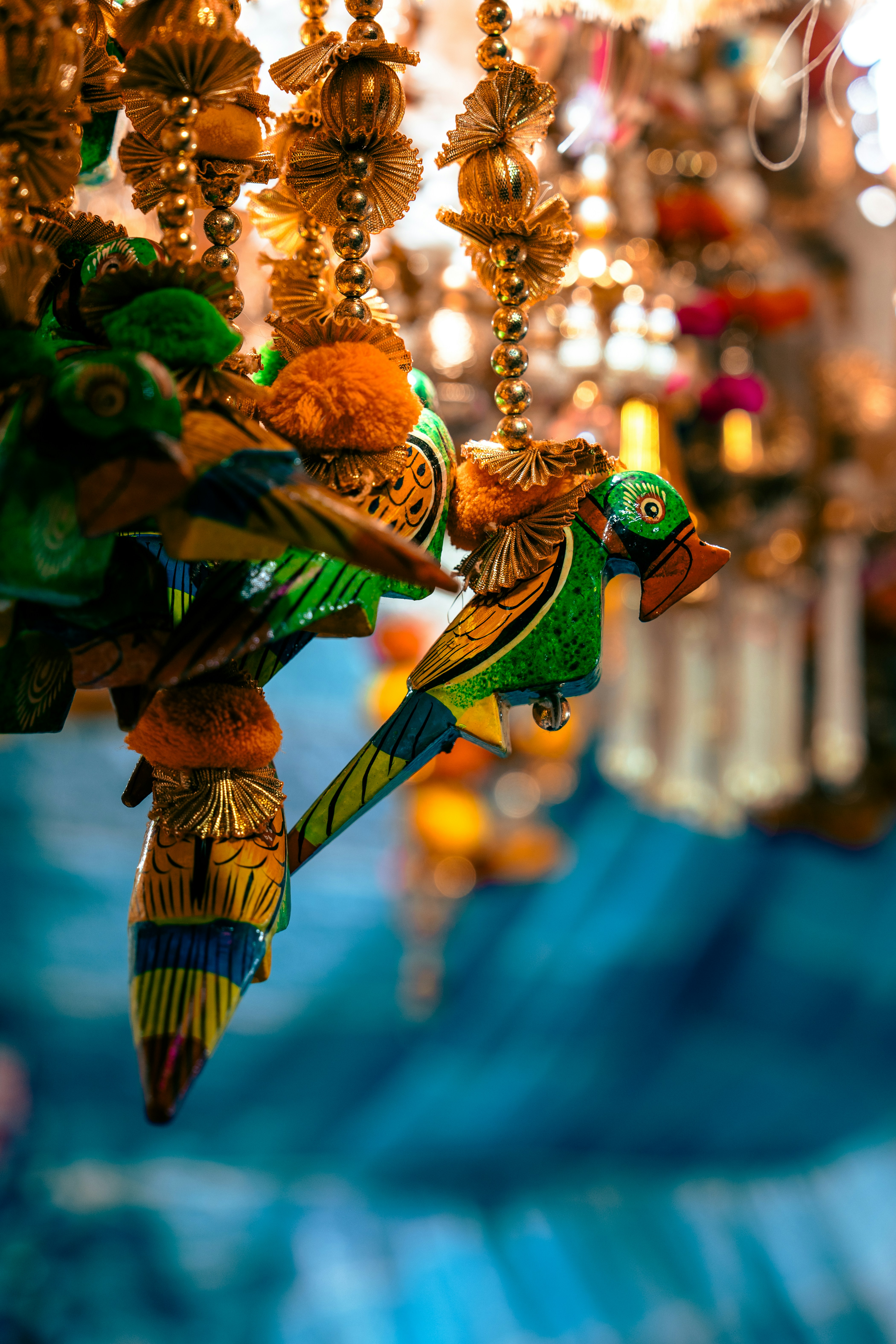 Emerald Parrot Amid Golden Tassels: Craft Beads in a Sunlit Market