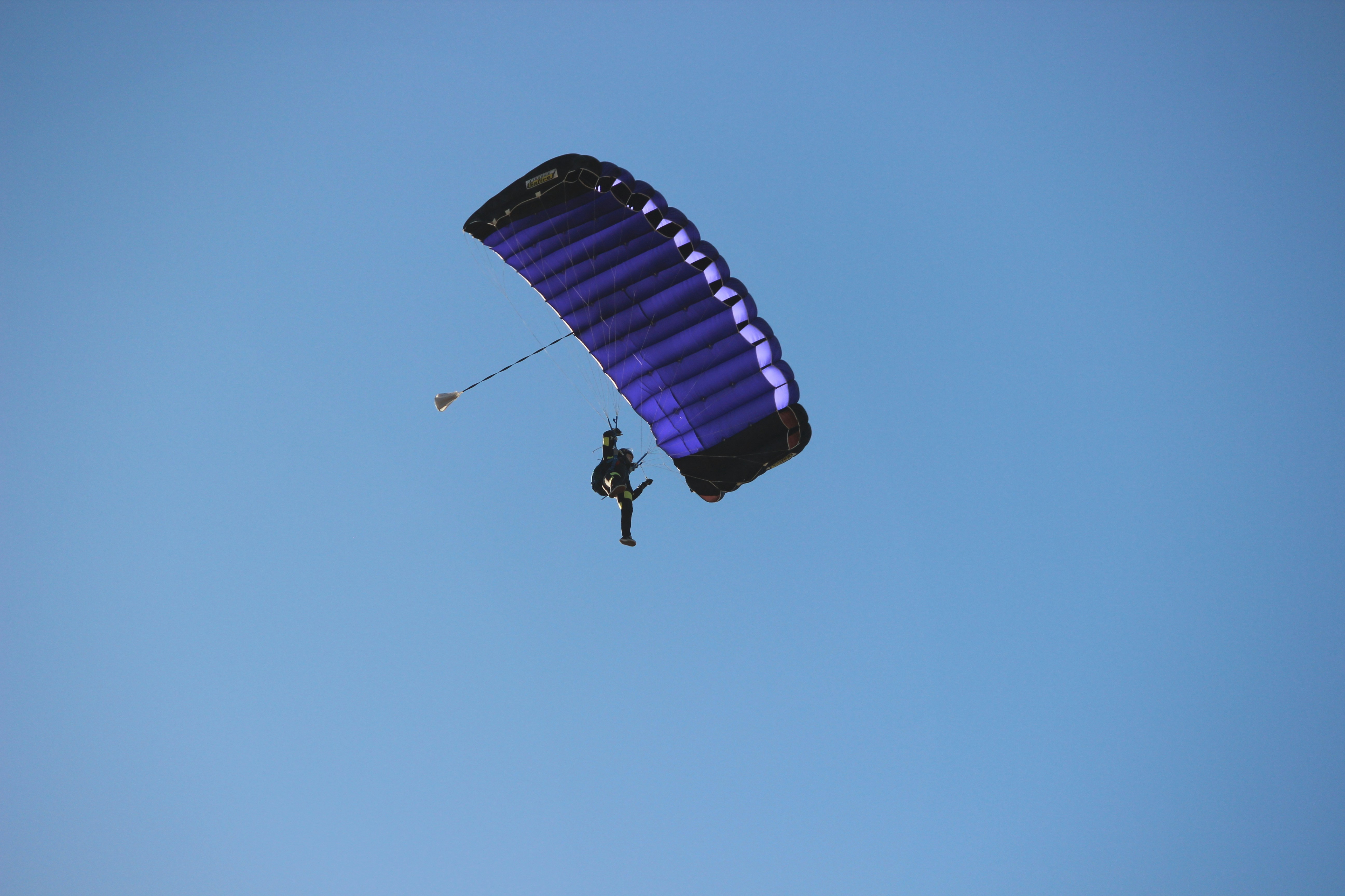 Violet Wing Over a Cerulean Sky: Solo Skydiver in Freefall