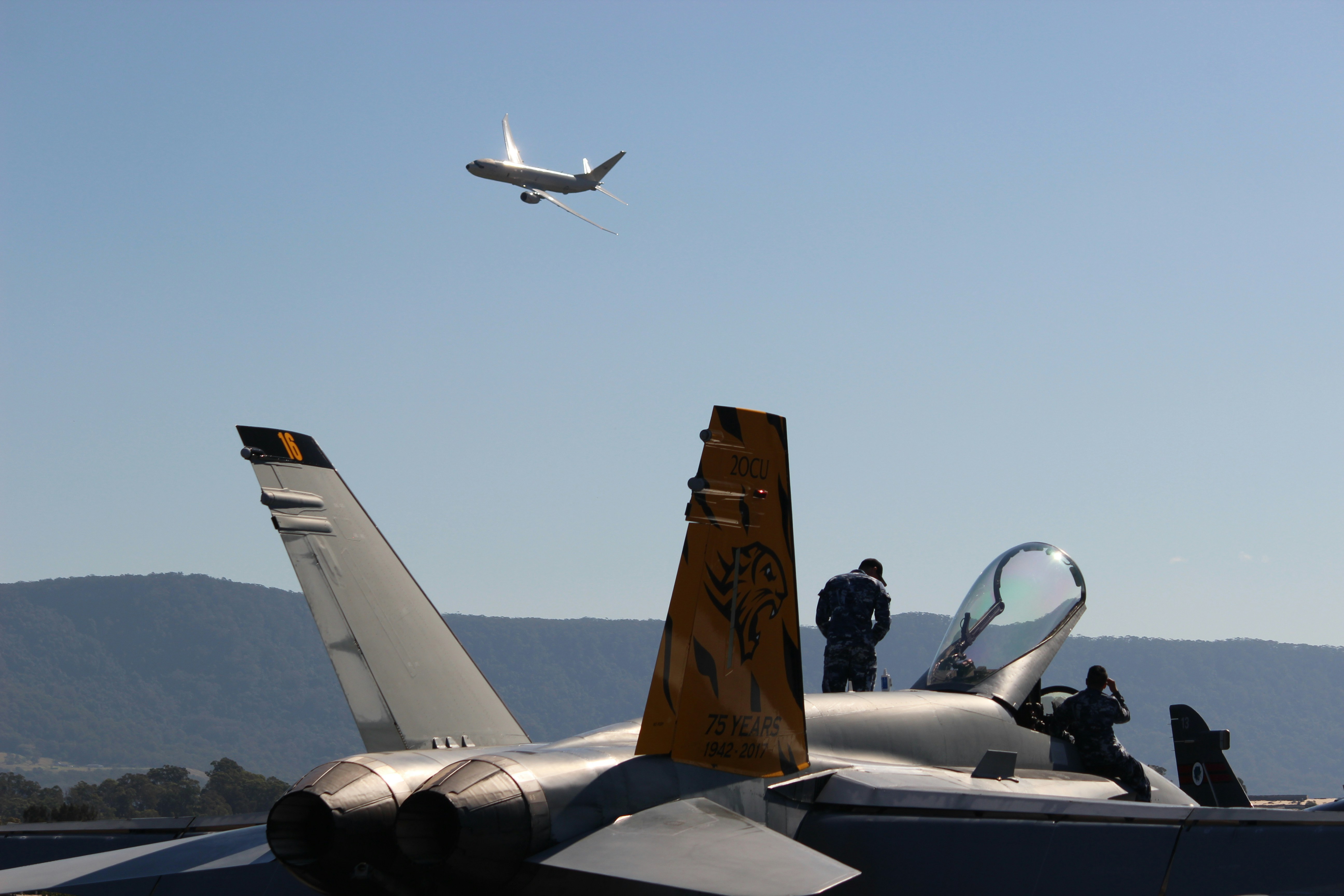 A jet plane flying over a boat on a body of water photo – Free Human ...